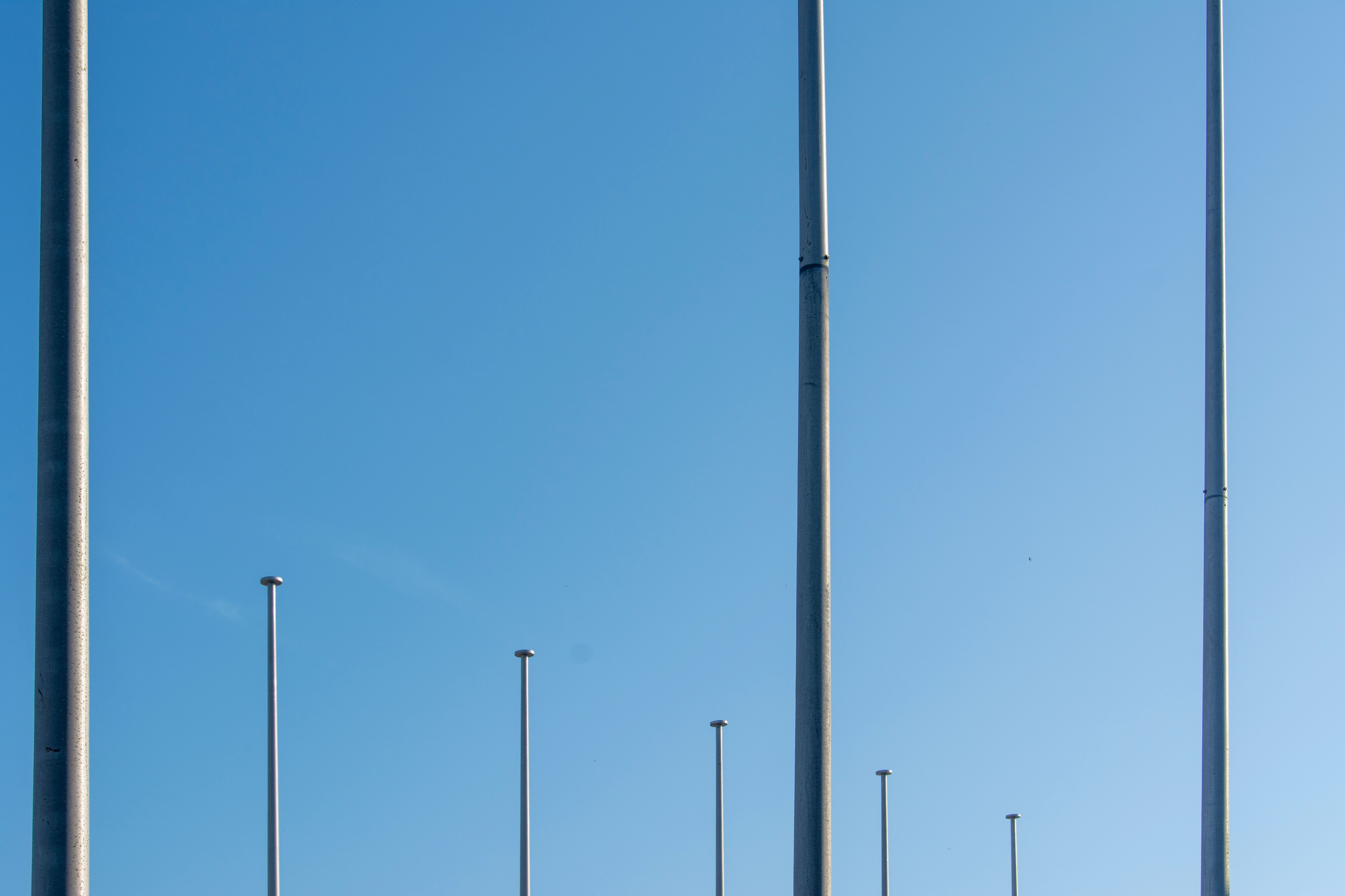 A row of poles with blue sky in the background · Free Stock Photo