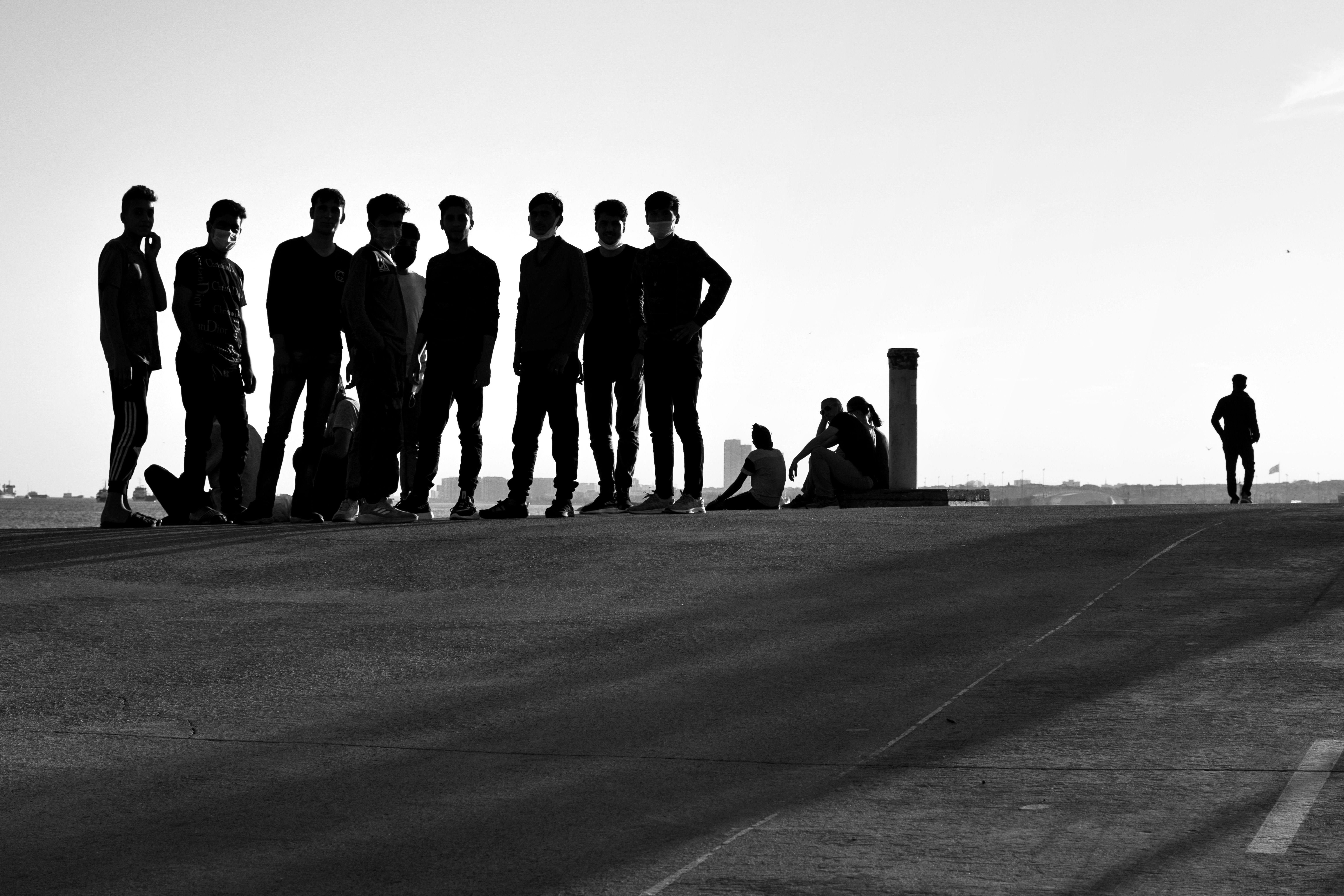 A group of people standing on the side of the road · Free Stock Photo