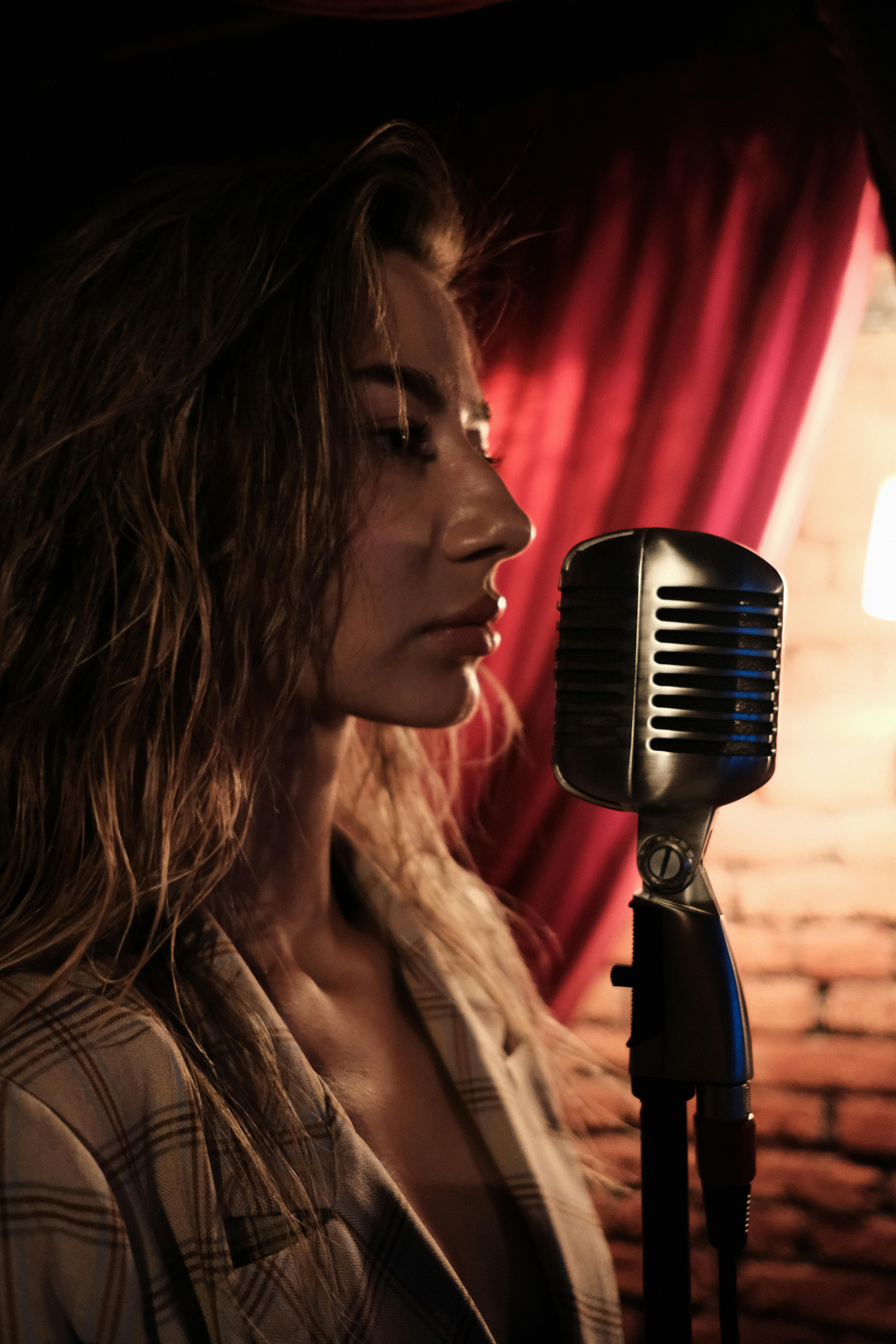 Side View of a Singer Standing next to a Microphone · Free Stock Photo