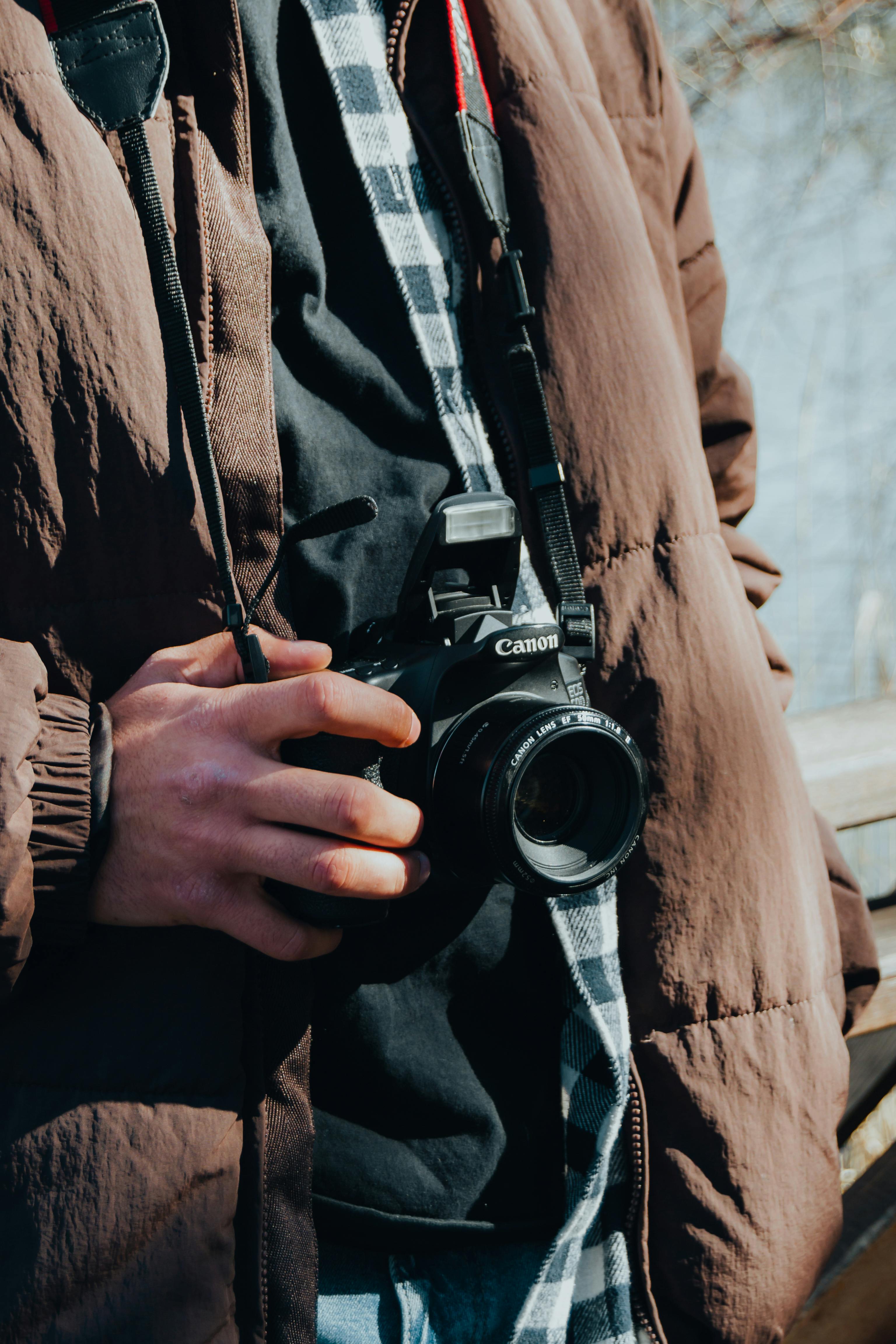 Man Sitting on Chair Holding Gray Camera · Free Stock Photo