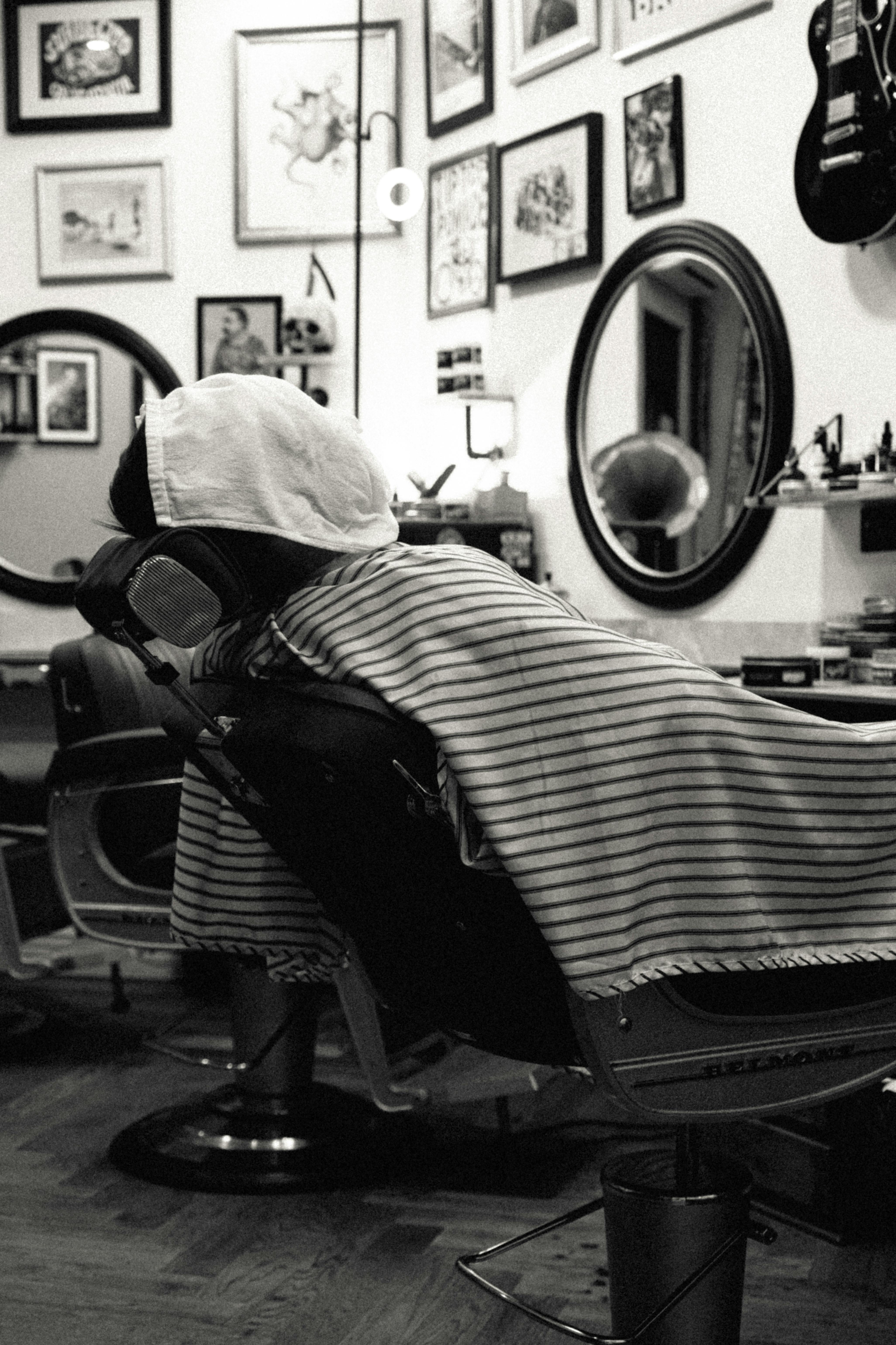 Customer in a Barbers Chair with a Towel on His Face · Free Stock Photo