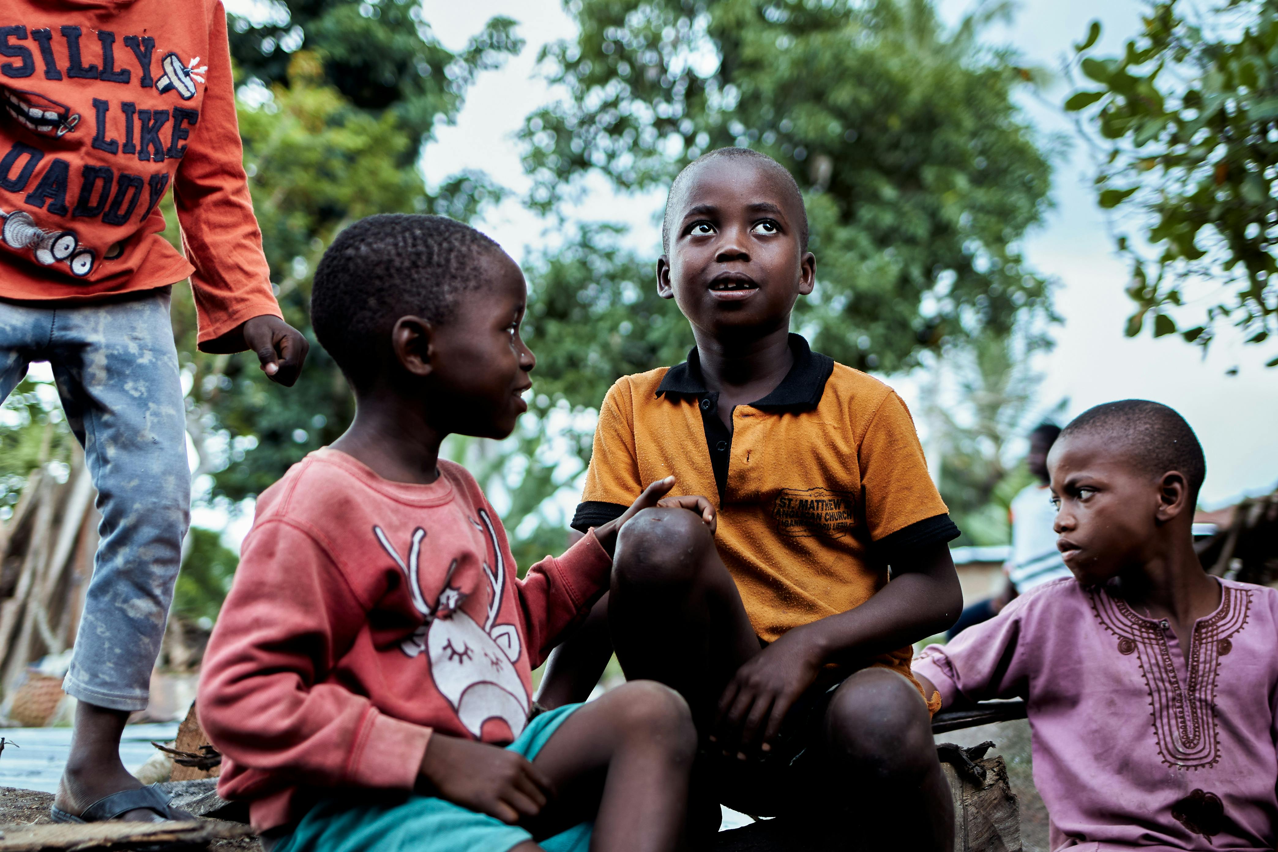 A Group of Children Sitting Outside · Free Stock Photo