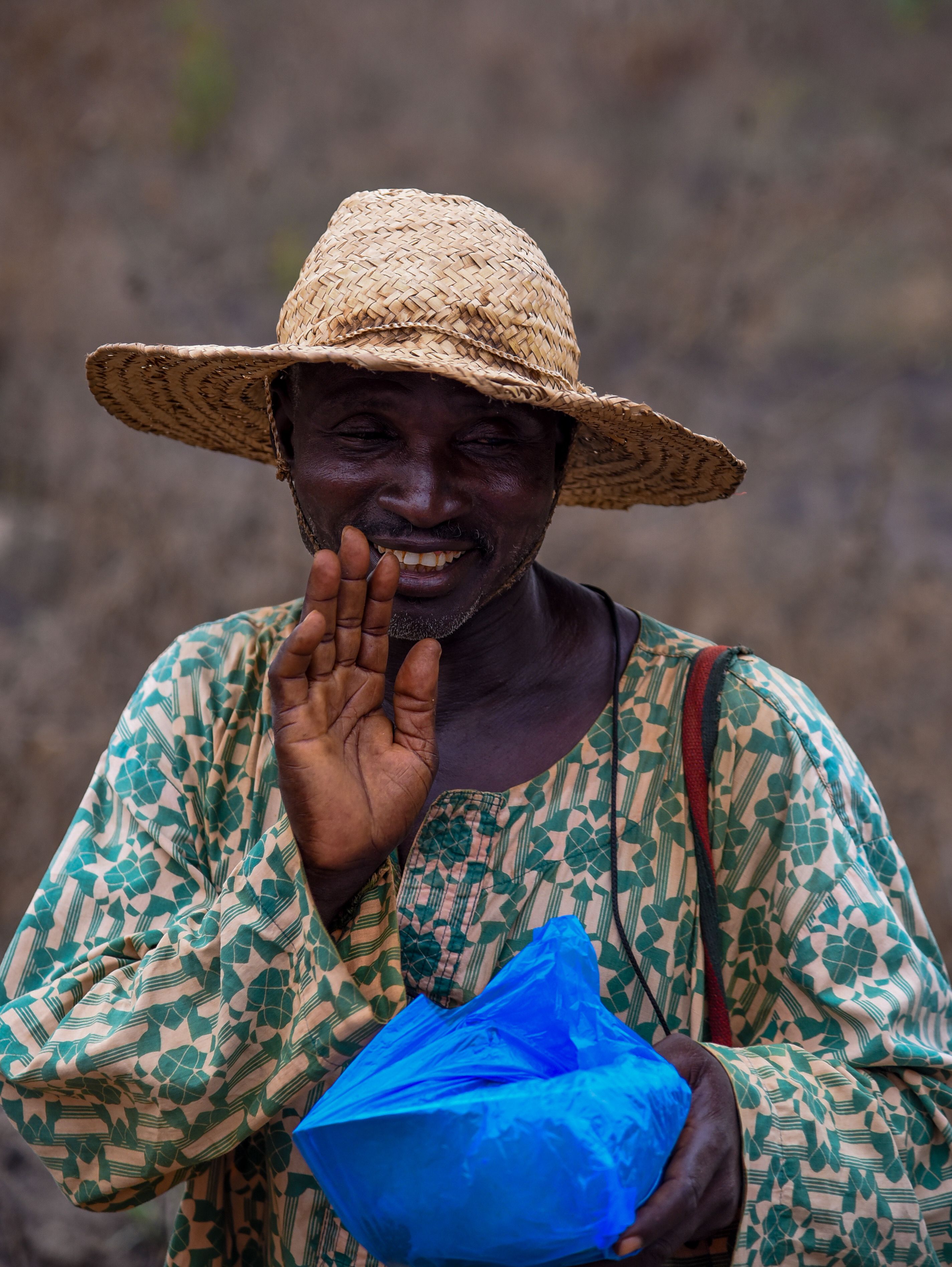Photo of a Smiling Man in a Hat Waving at the Camera · Free Stock Photo