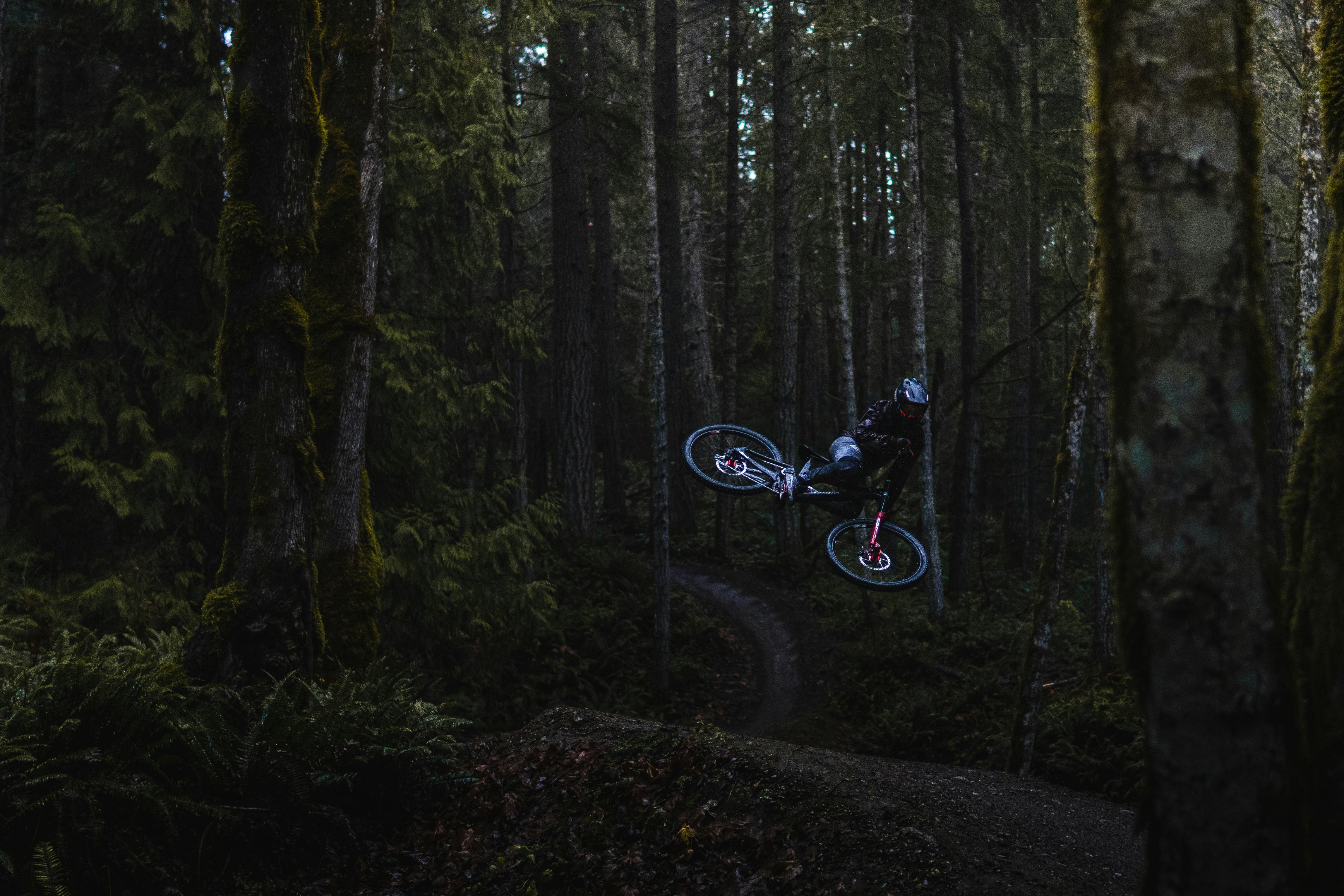 Cyclist in Jump Training Downhill in Forest · Free Stock Photo
