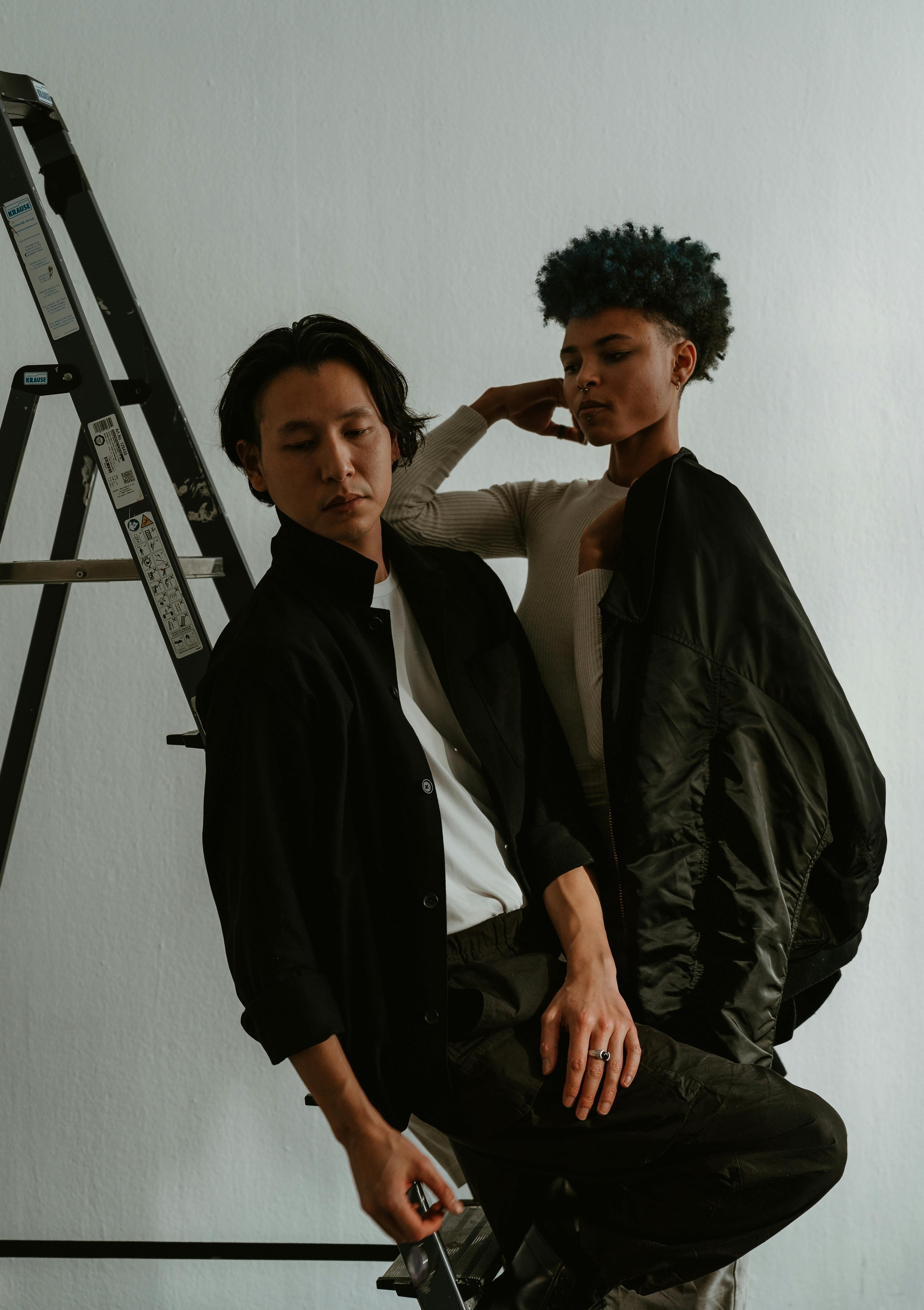 Two Fashion Models Posing by a Ladder · Free Stock Photo