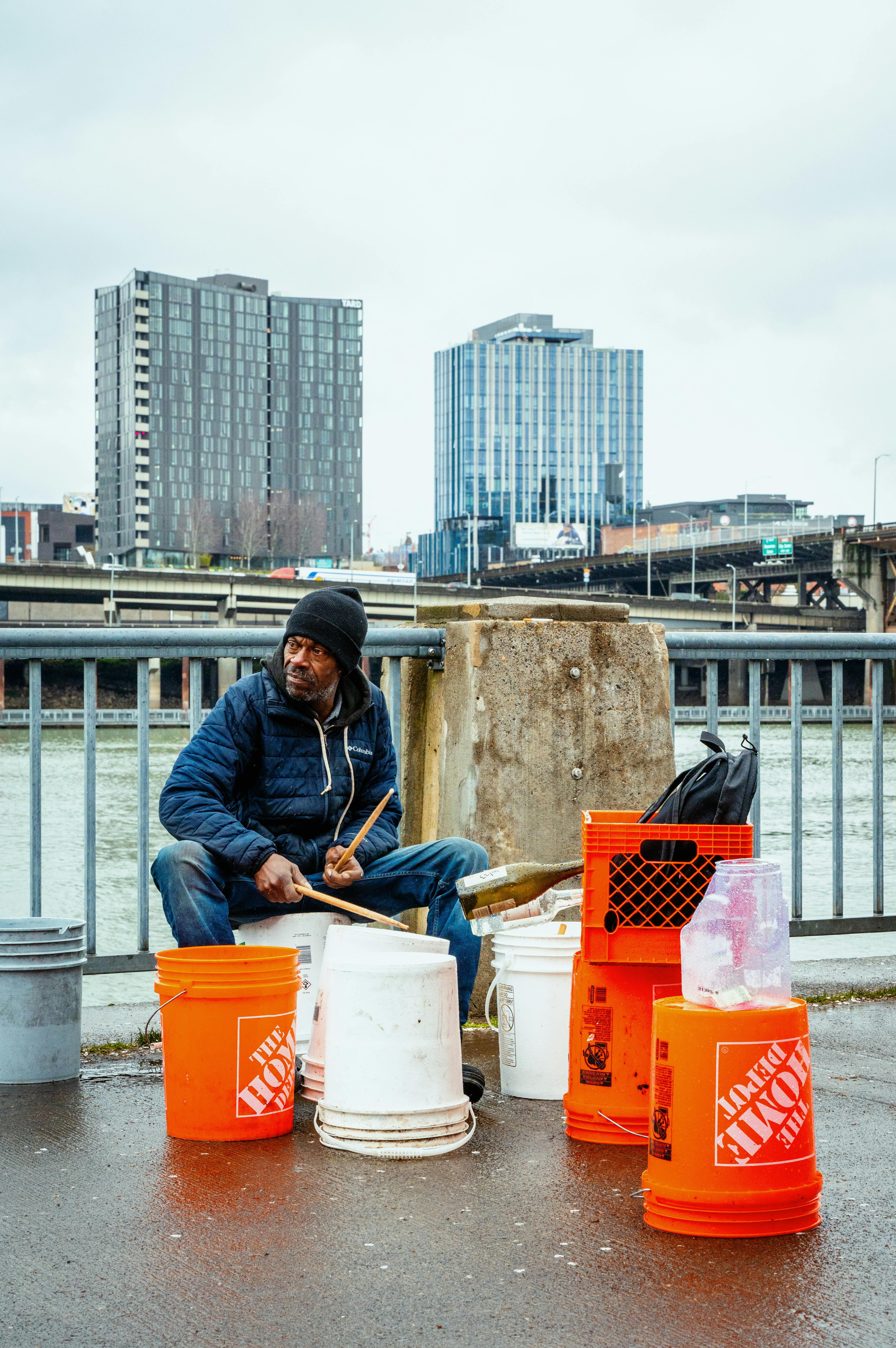 Man Sitting with Drumsticks and Buckets · Free Stock Photo