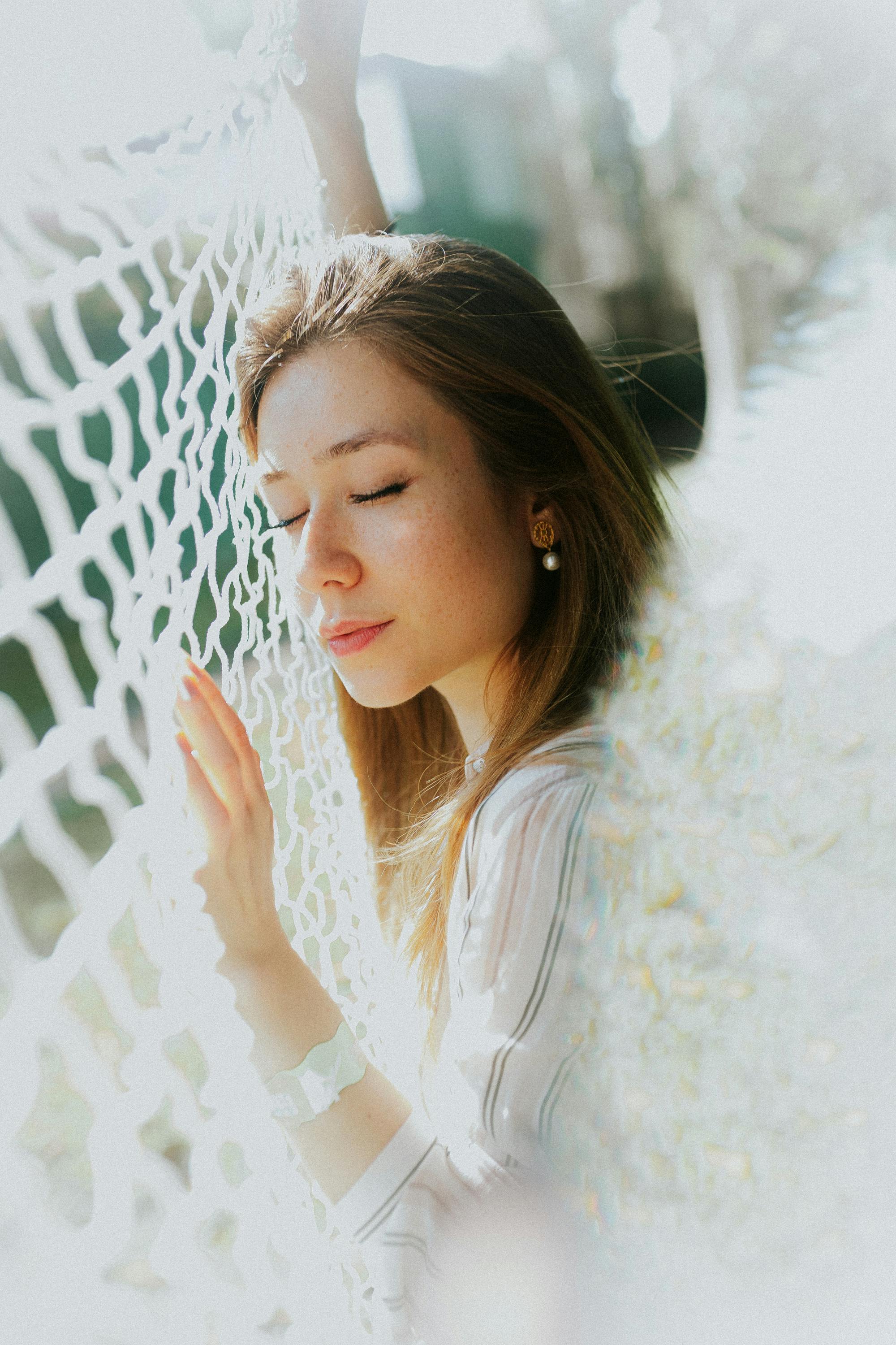 Woman with Eyes Closed Touching Net · Free Stock Photo