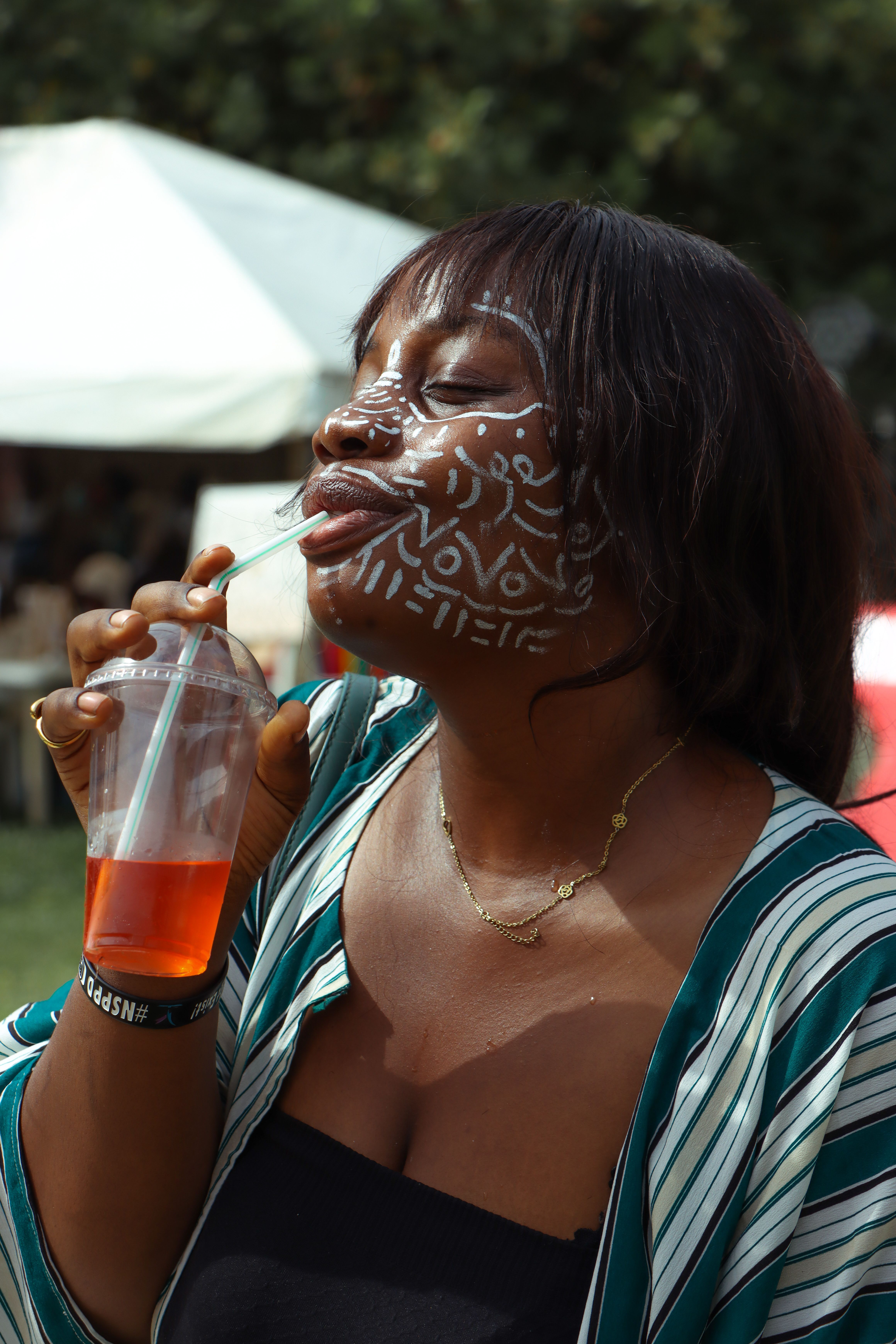 Woman with Painted Face Drinking from Cup · Free Stock Photo