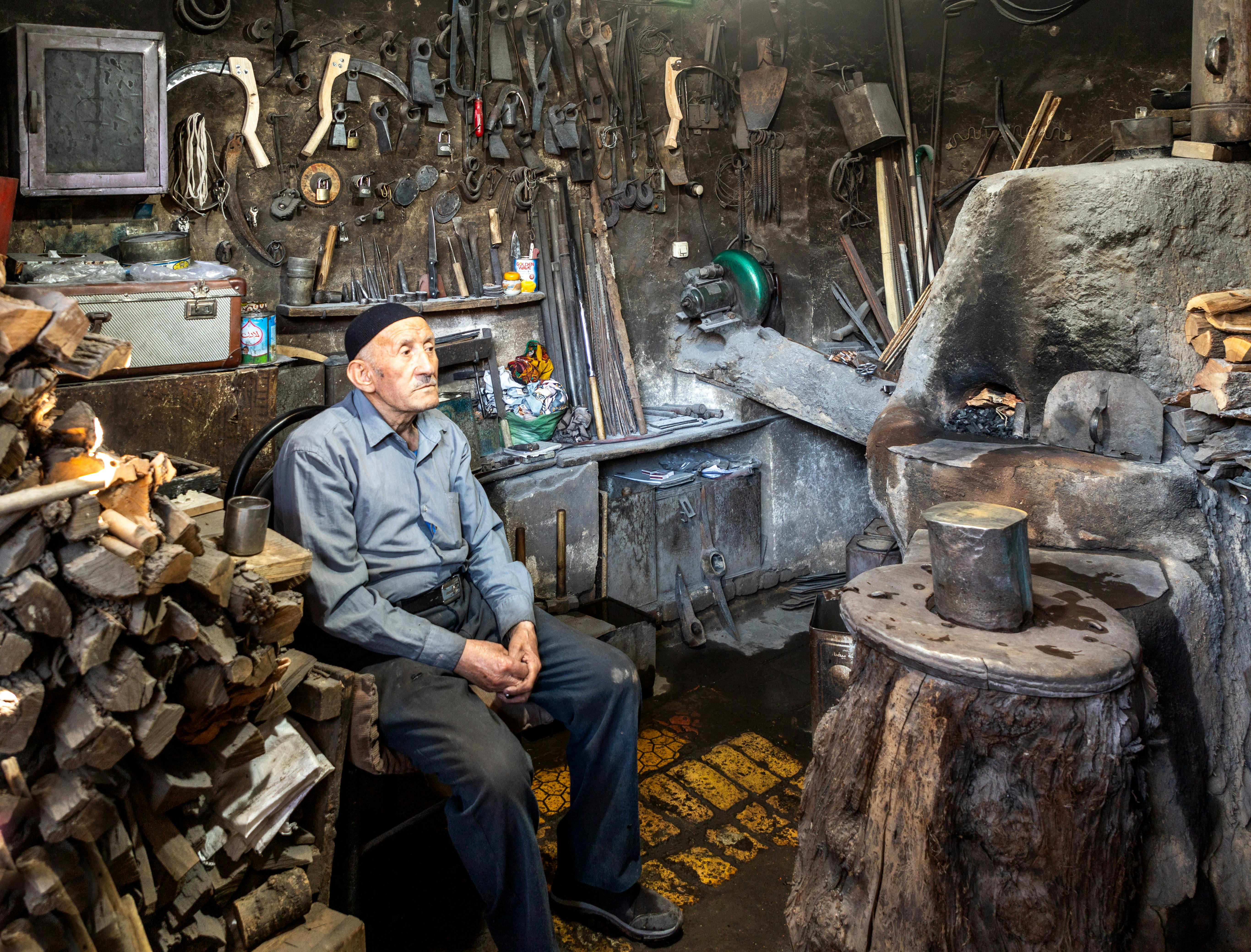 Elderly Artisan Sitting in Workshop · Free Stock Photo