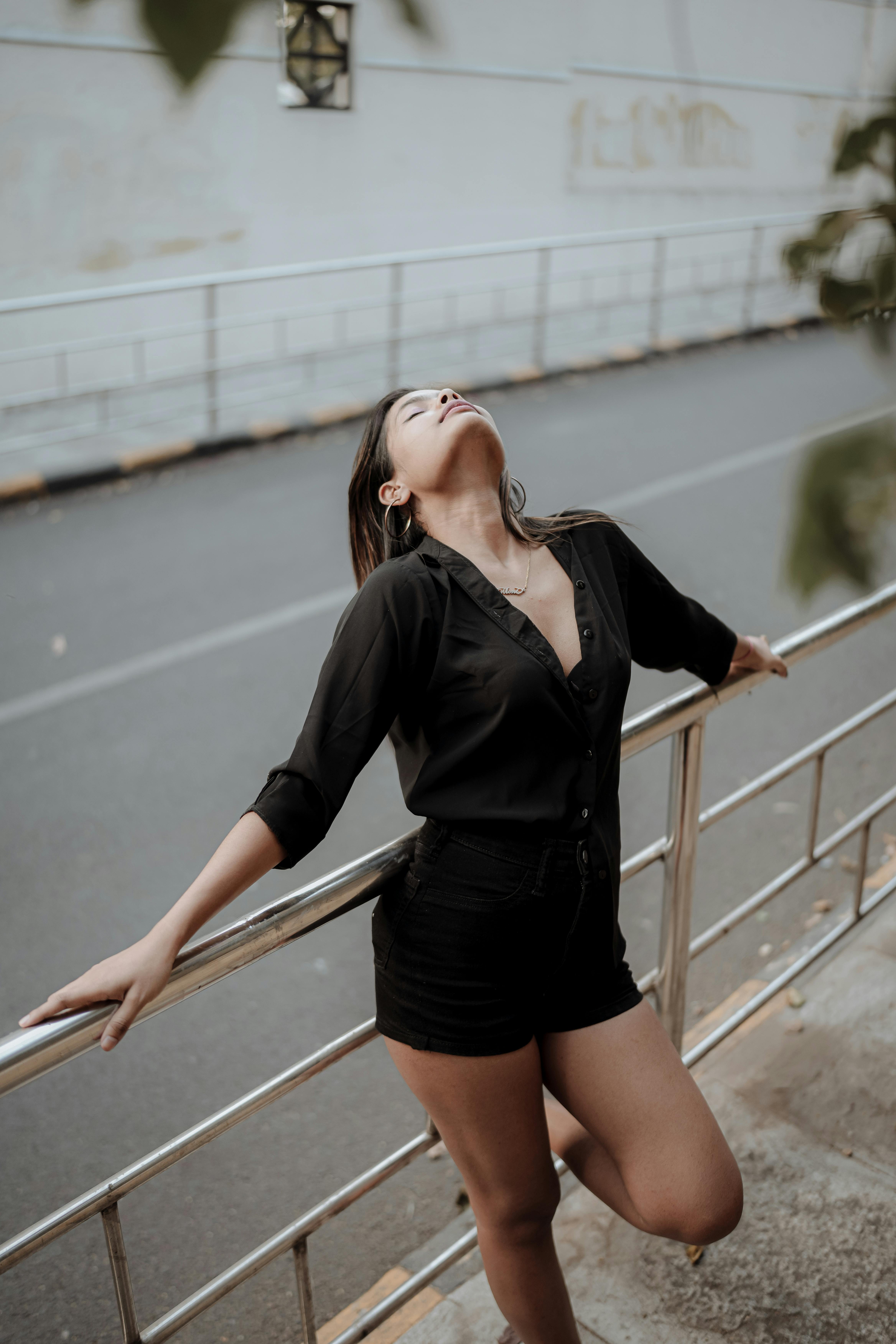 Young Woman Standing near the Railing with Her Head Thrown Back · Free ...
