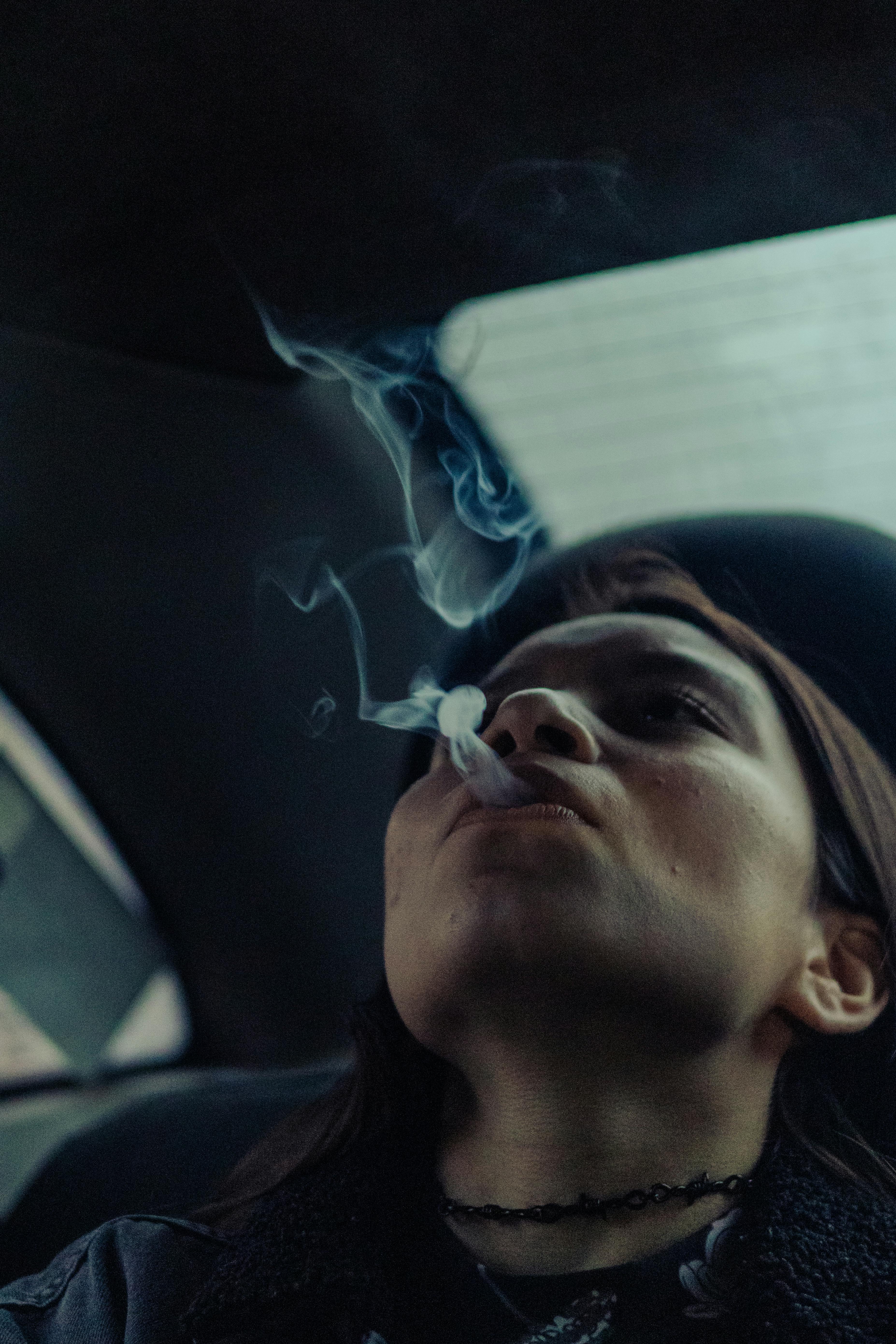 Woman Blowing Smoke While Sitting in the Backseat of a Car · Free Stock ...