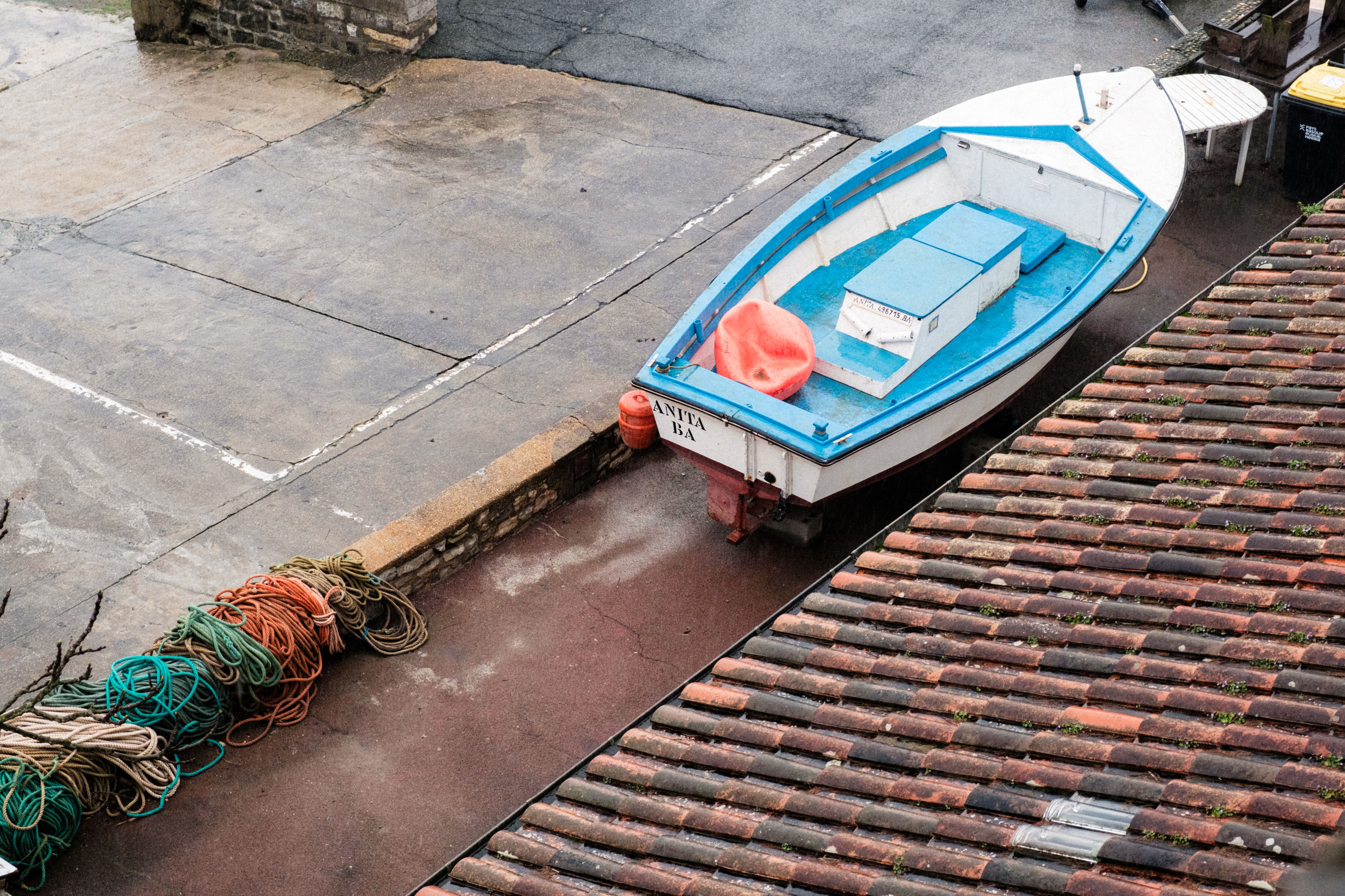 A boat is tied to a dock on a rainy day · Free Stock Photo