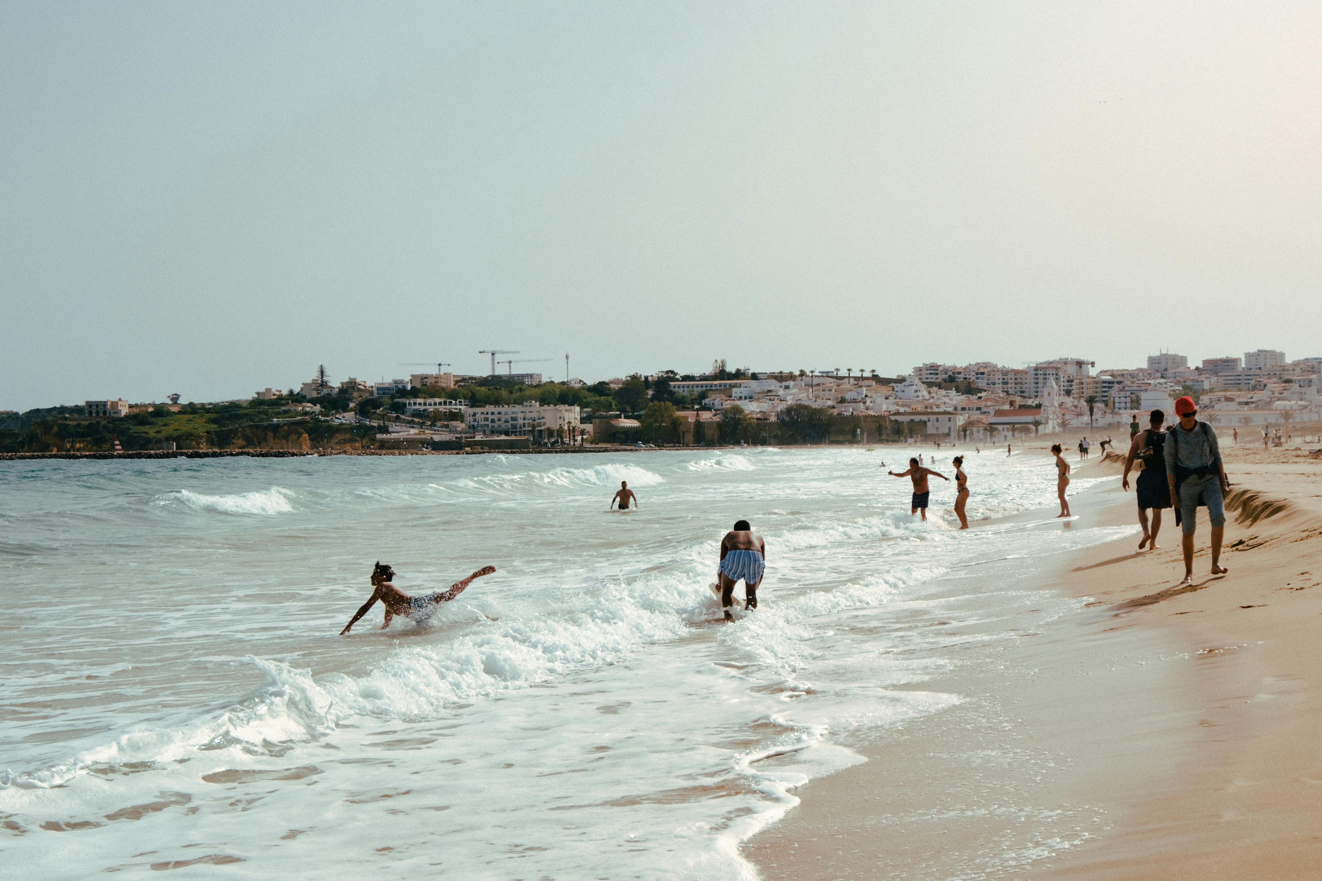 View of People Bathing in the Ocean and Walking on a Beach · Free Stock ...