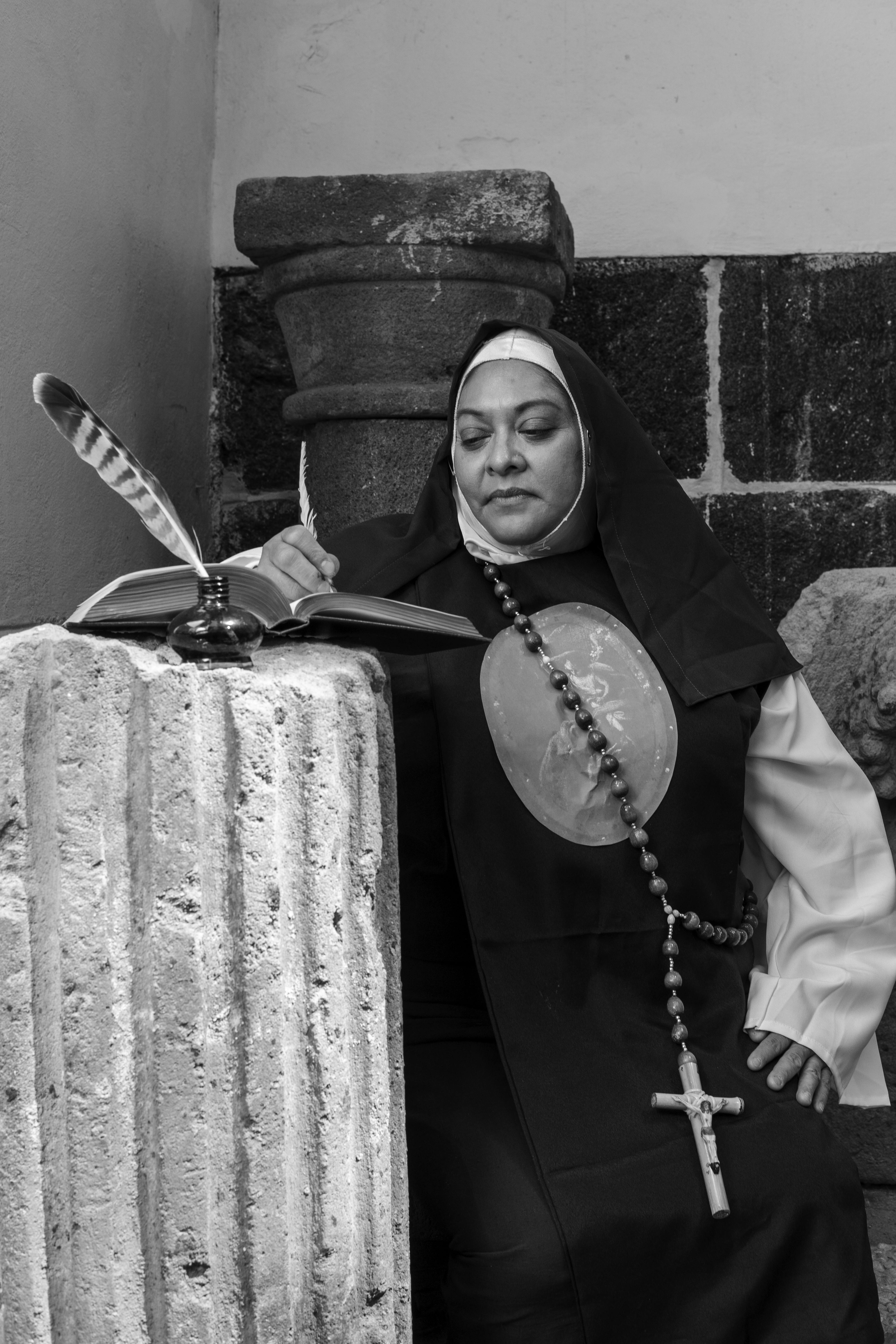 Nun Writing in Book in Black and White · Free Stock Photo