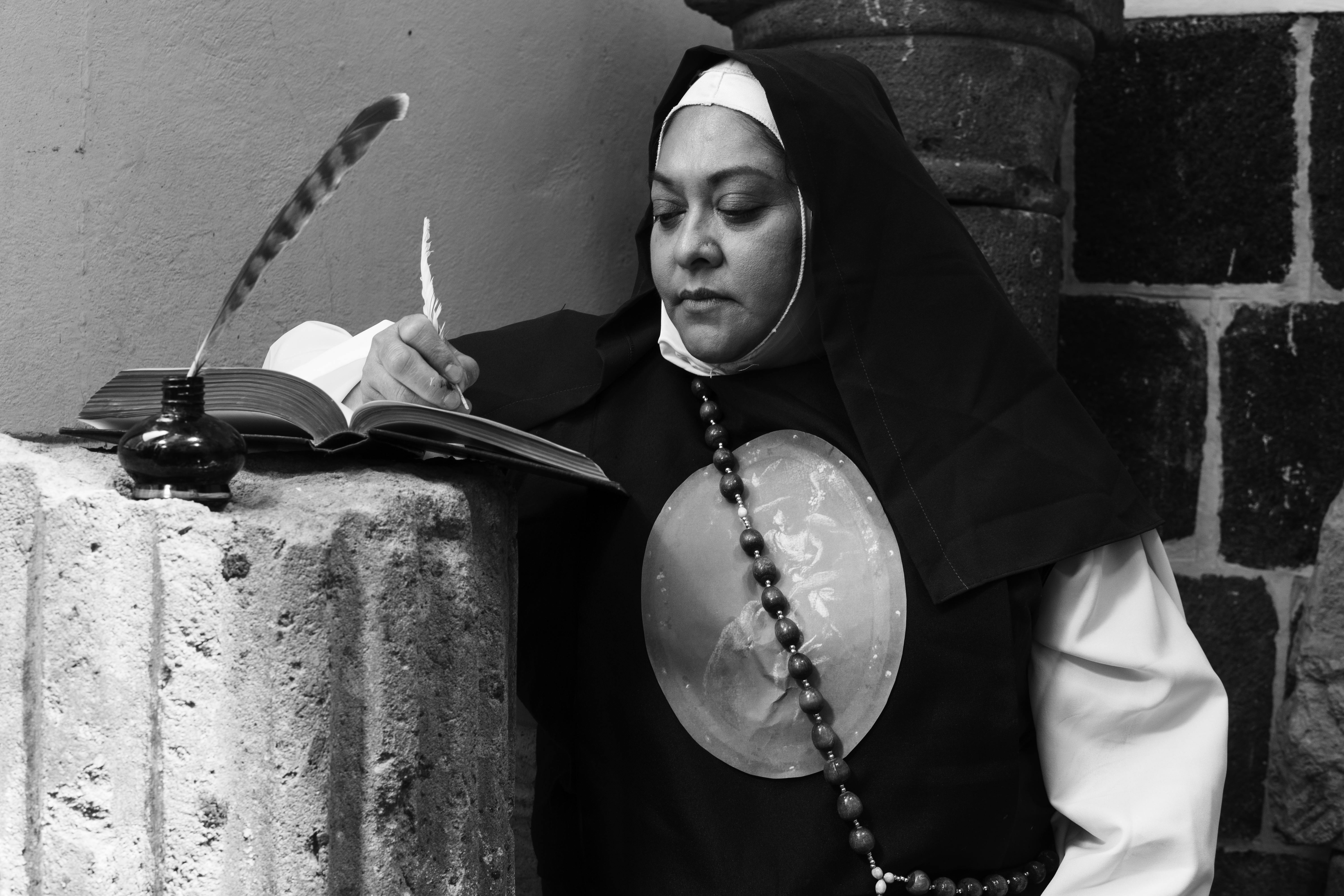 Nun Sitting and Writing in Book in Black and White · Free Stock Photo