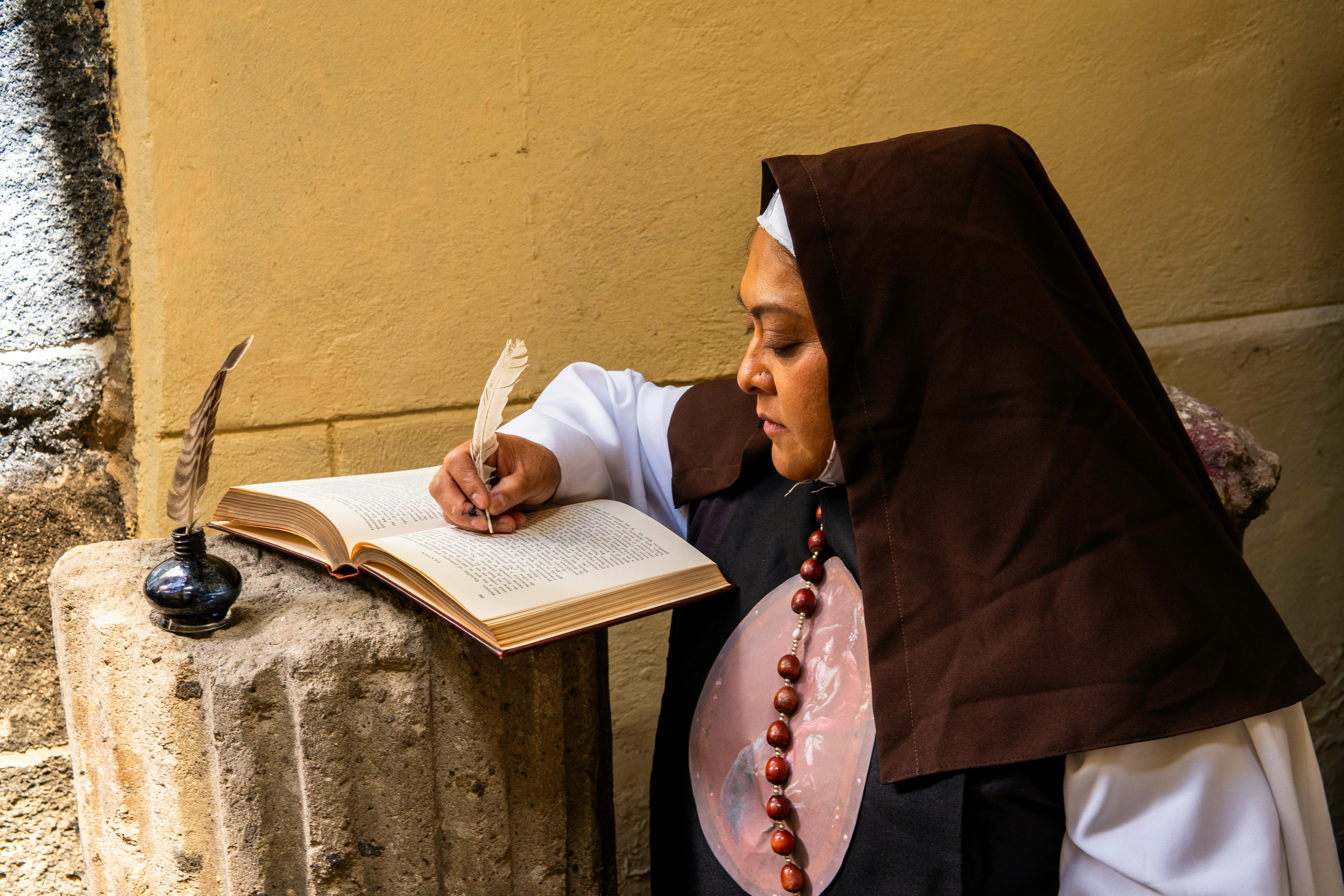A nun writing in a book · Free Stock Photo