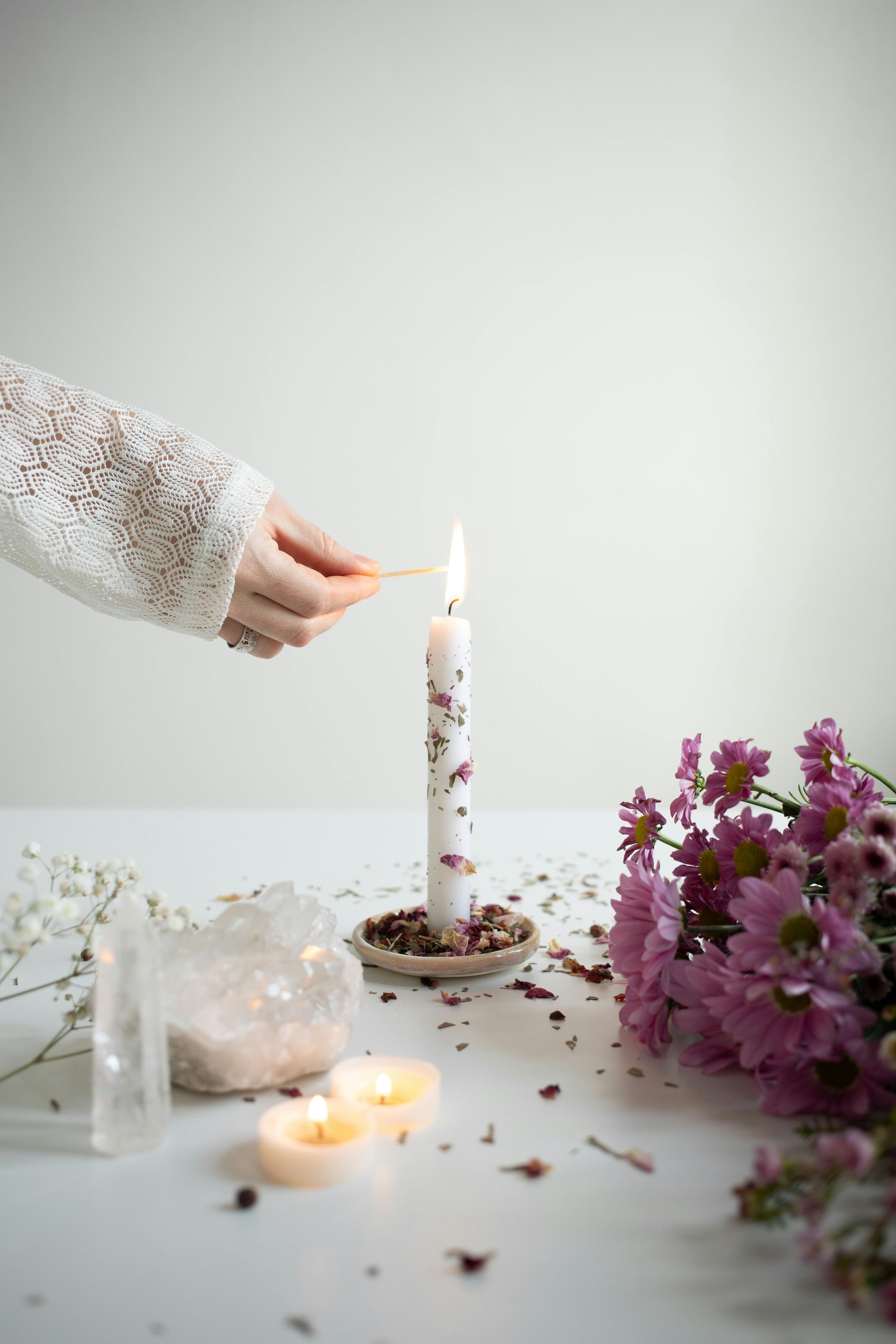 Woman Holding Her Hand near a Burning Candlestick Standing on a Table ...