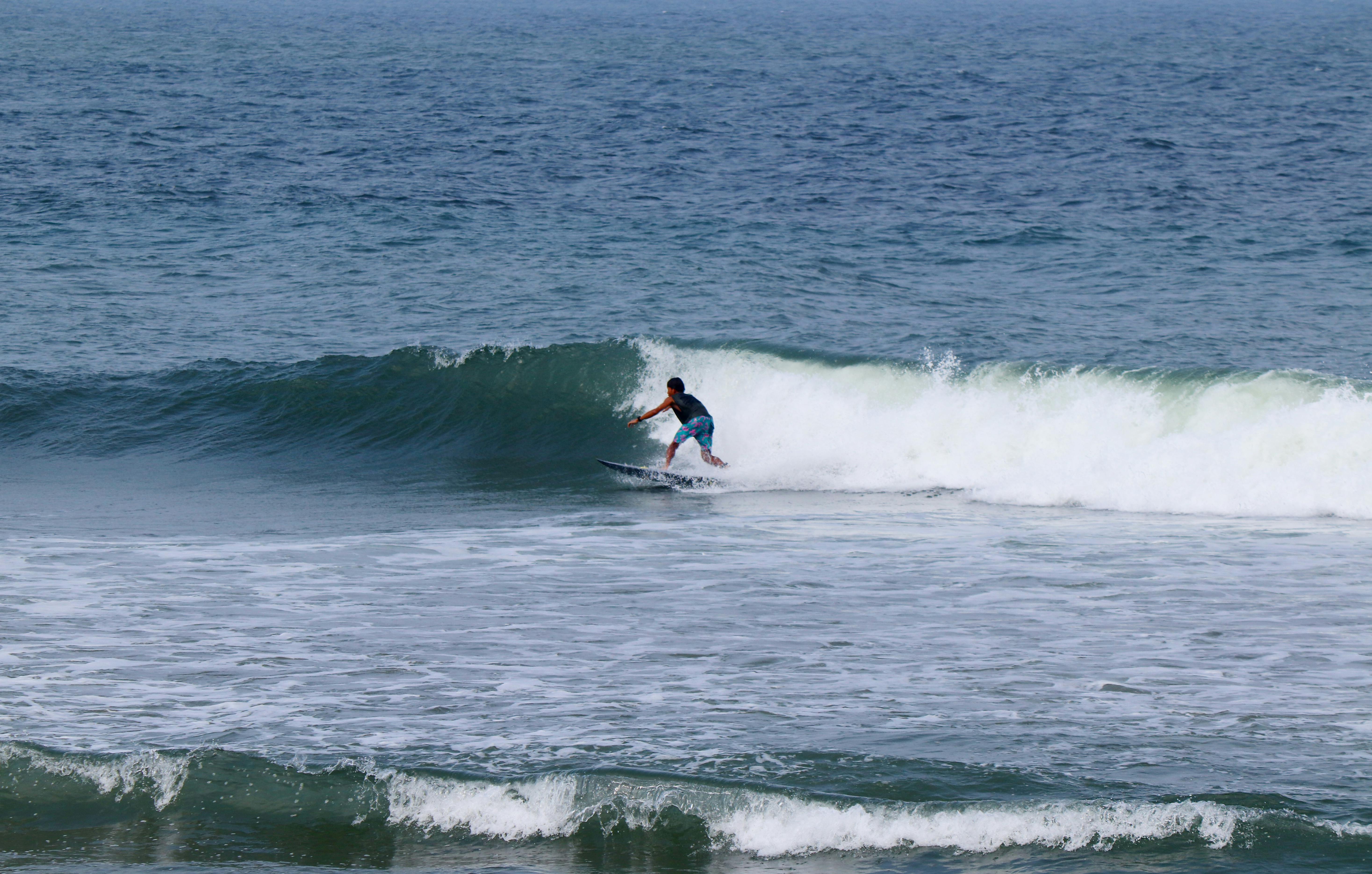 A person riding a surfboard in the ocean · Free Stock Photo