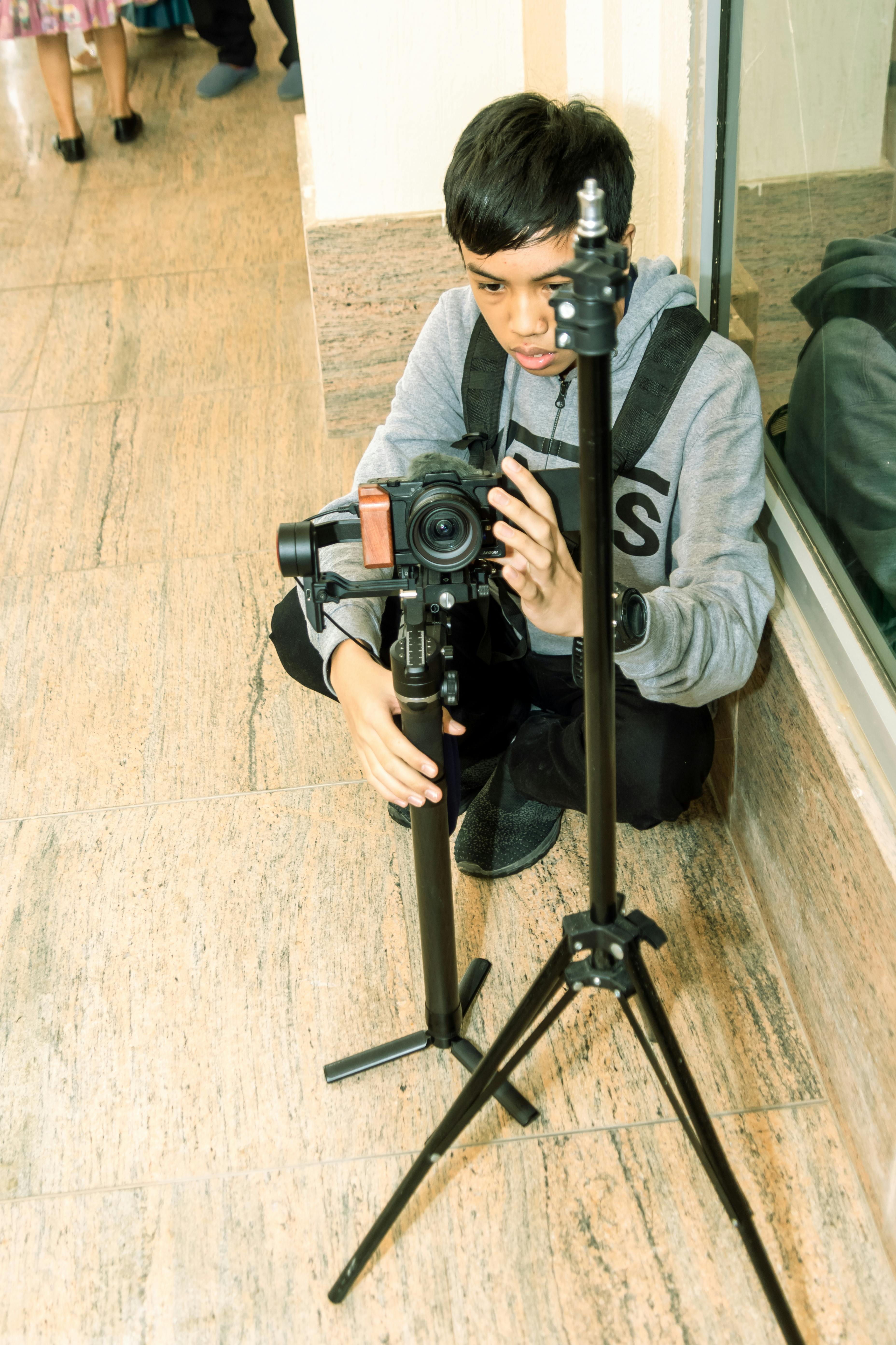 Young man Using a Camera on a Tripod · Free Stock Photo