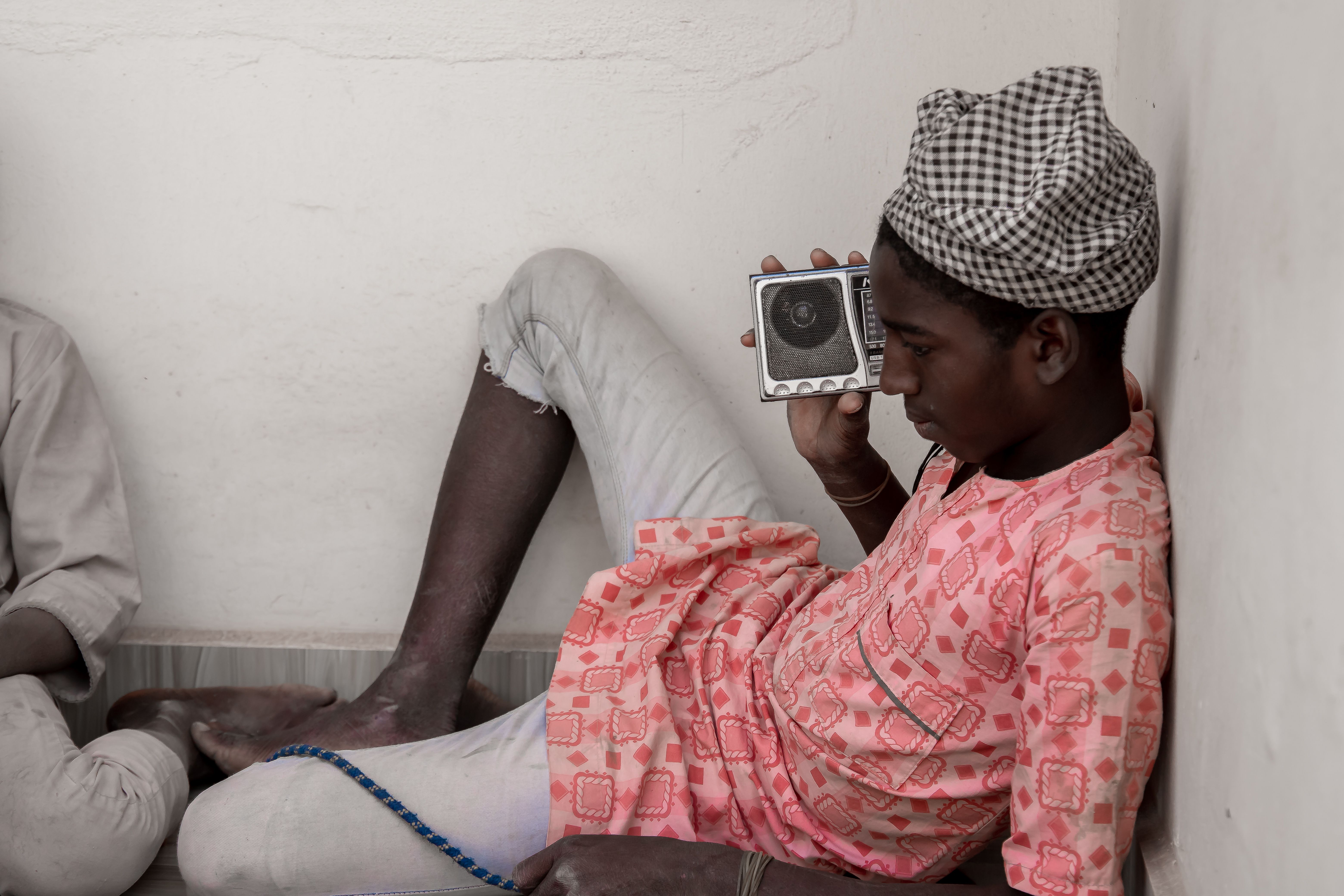 A boy sits on the floor with a camera · Free Stock Photo