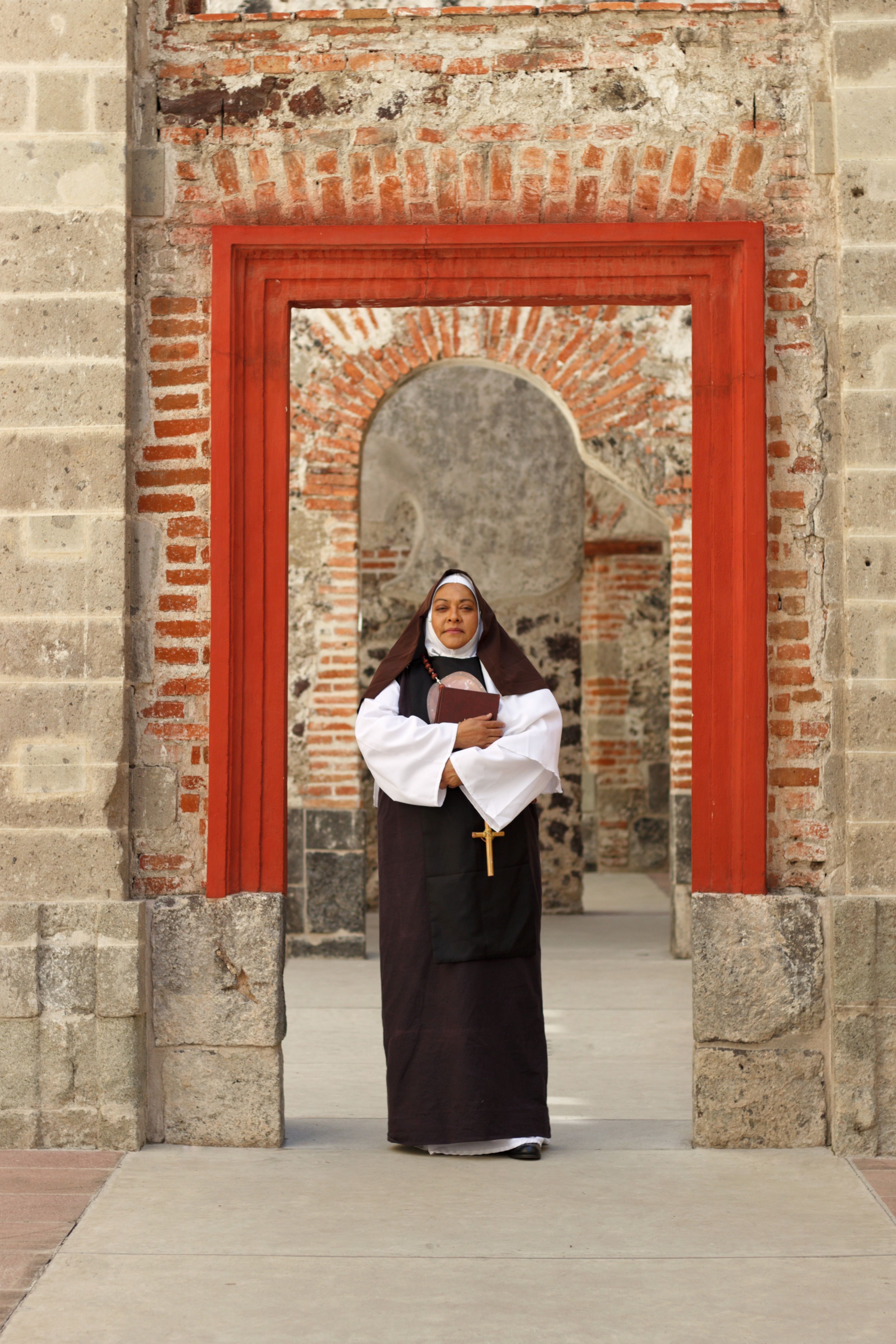 Nun in Vestments Standing in Doorway · Free Stock Photo