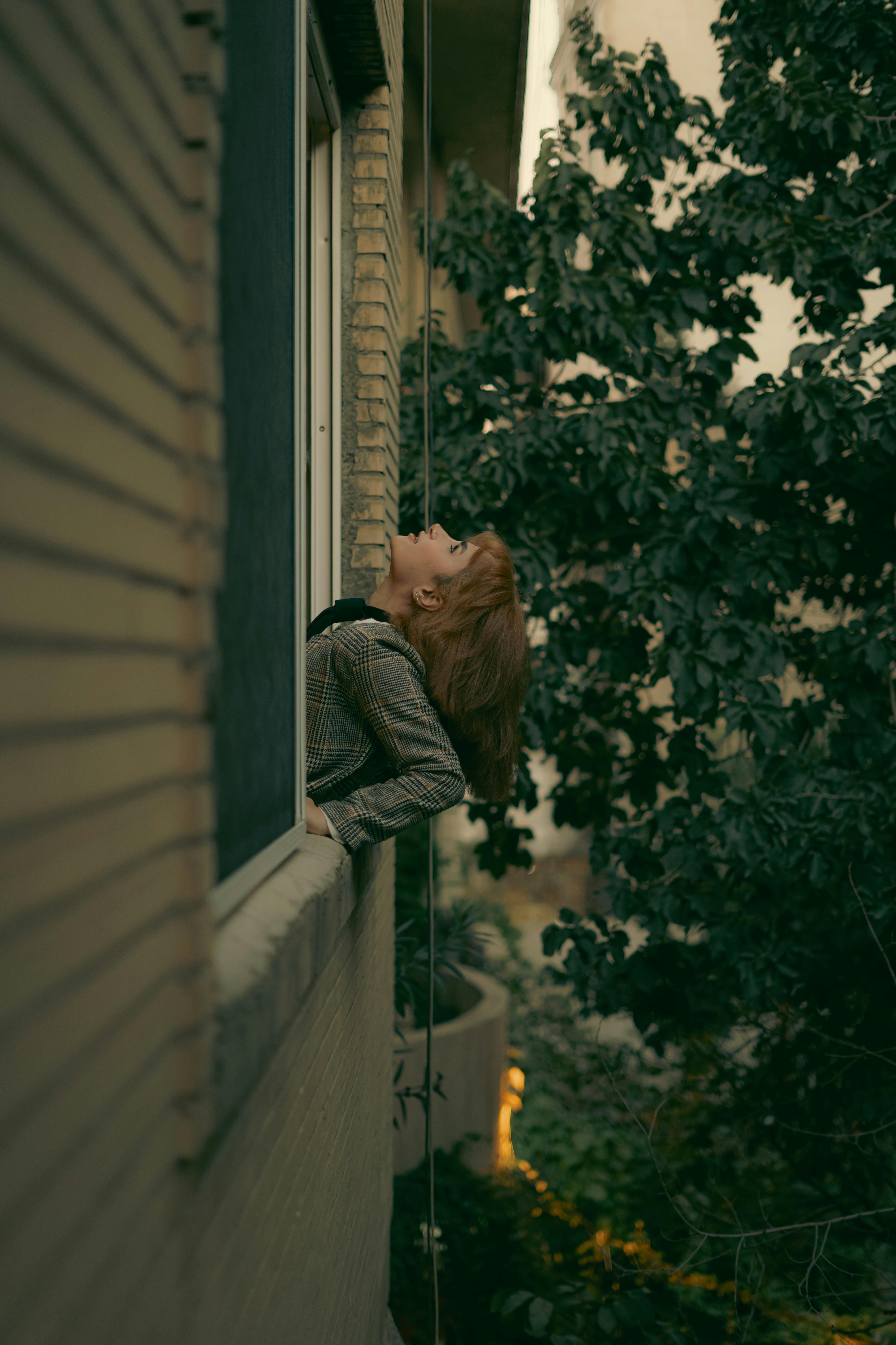 Young Woman Leaning Out the Window of a House · Free Stock Photo