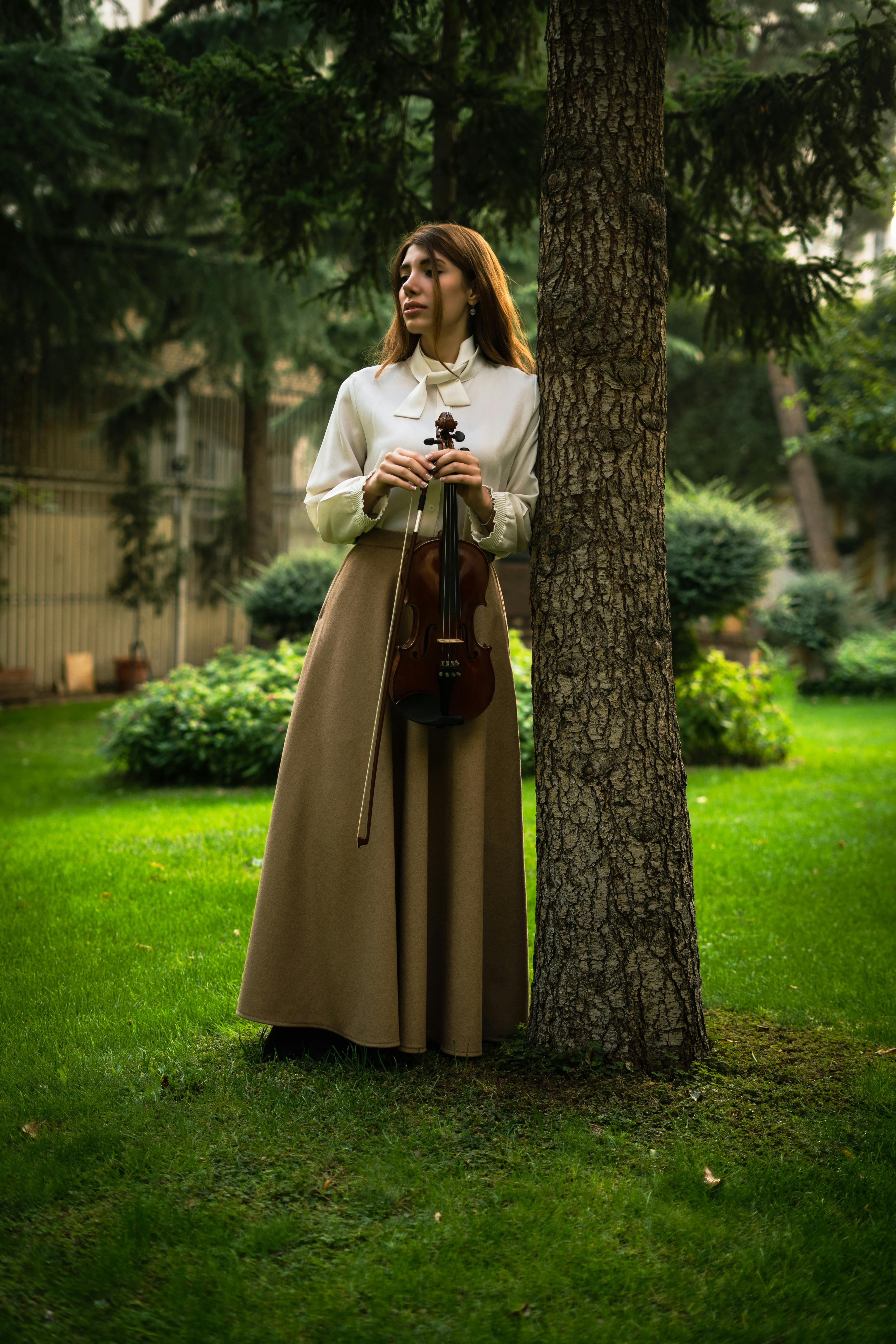Woman with a Violin Standing Under a Tree · Free Stock Photo