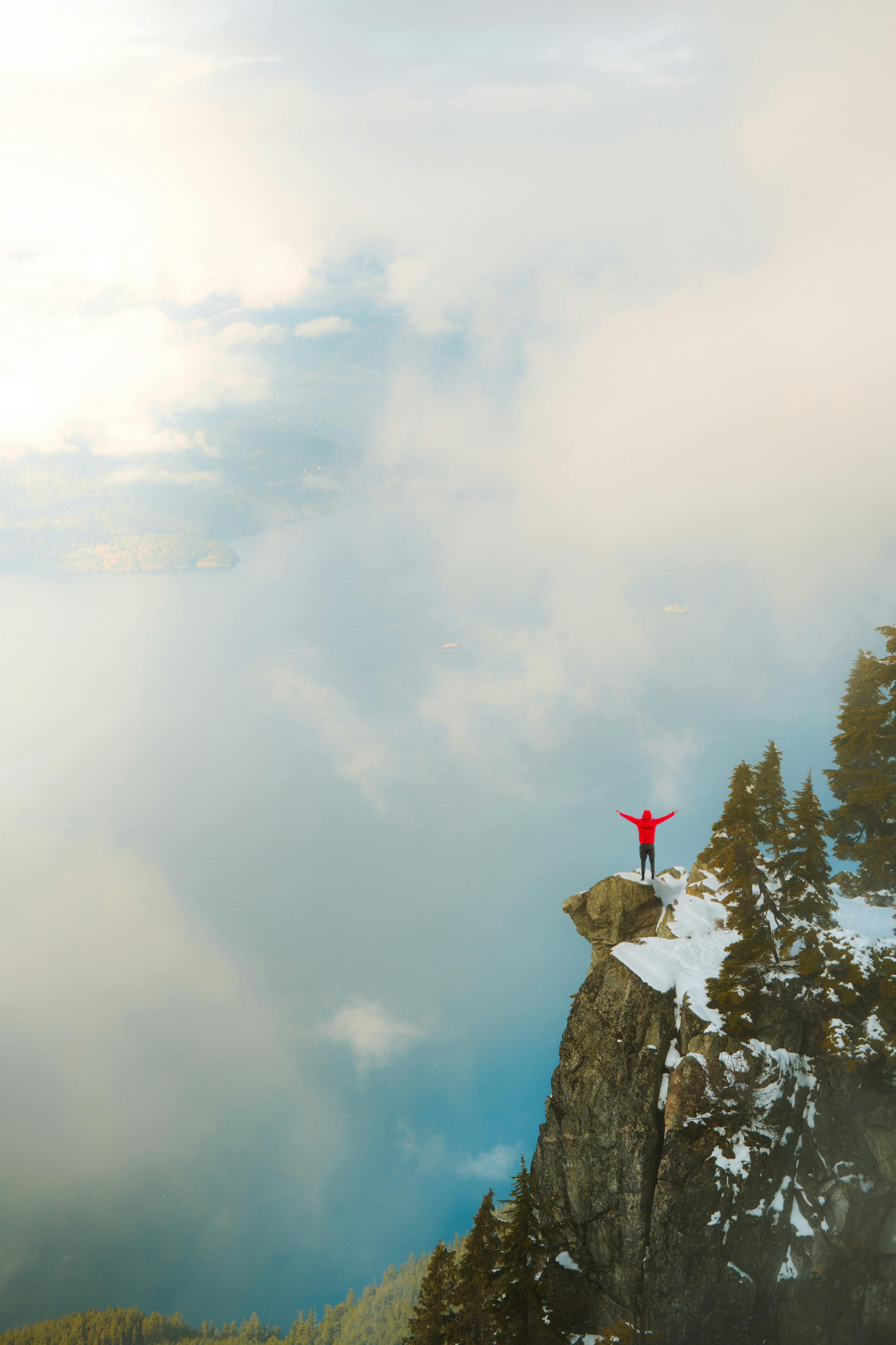 Hiker on the Edge of Steep Mountains · Free Stock Photo