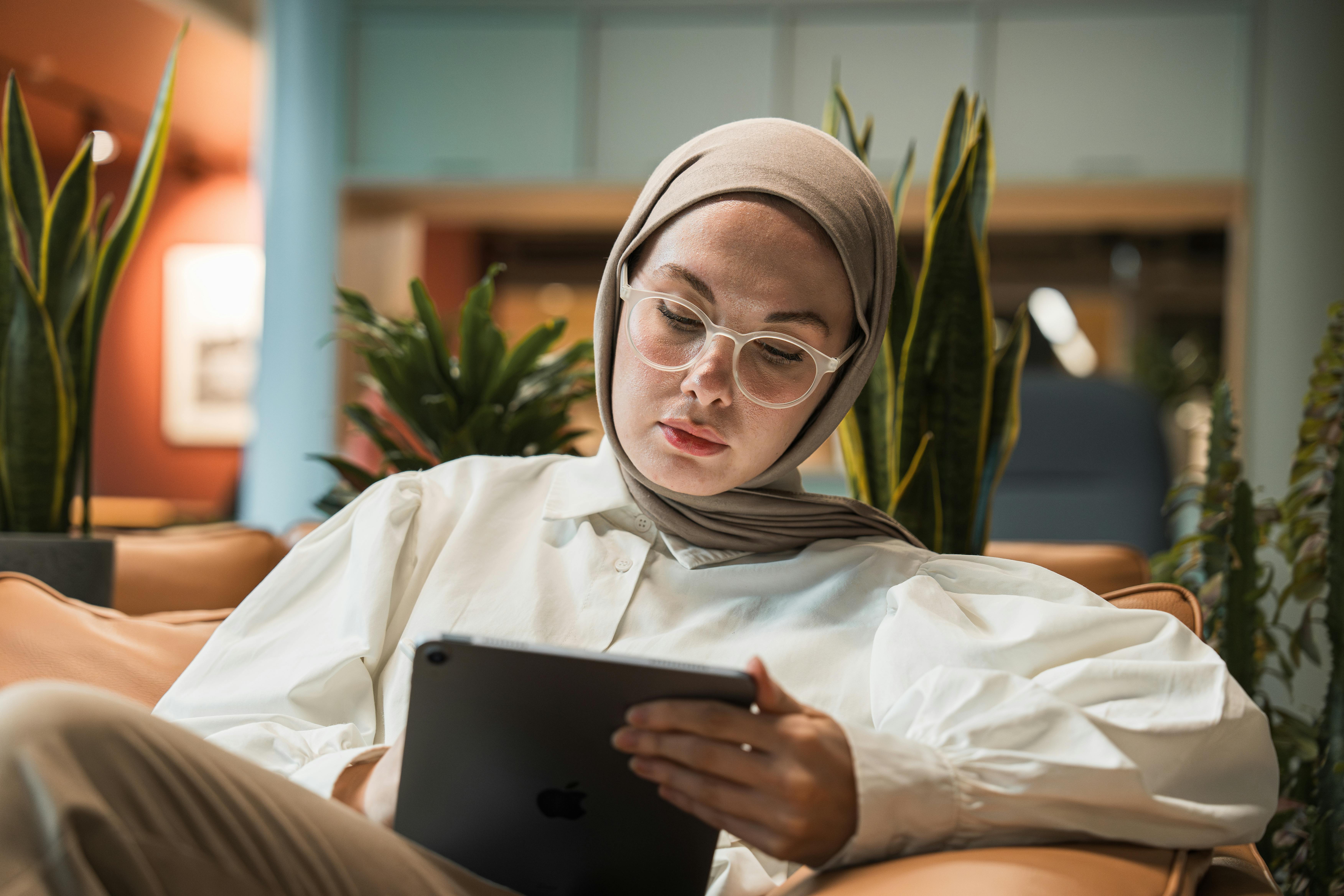 Woman In a Hijab Sitting In a Cafe with her Tablet · Free Stock Photo