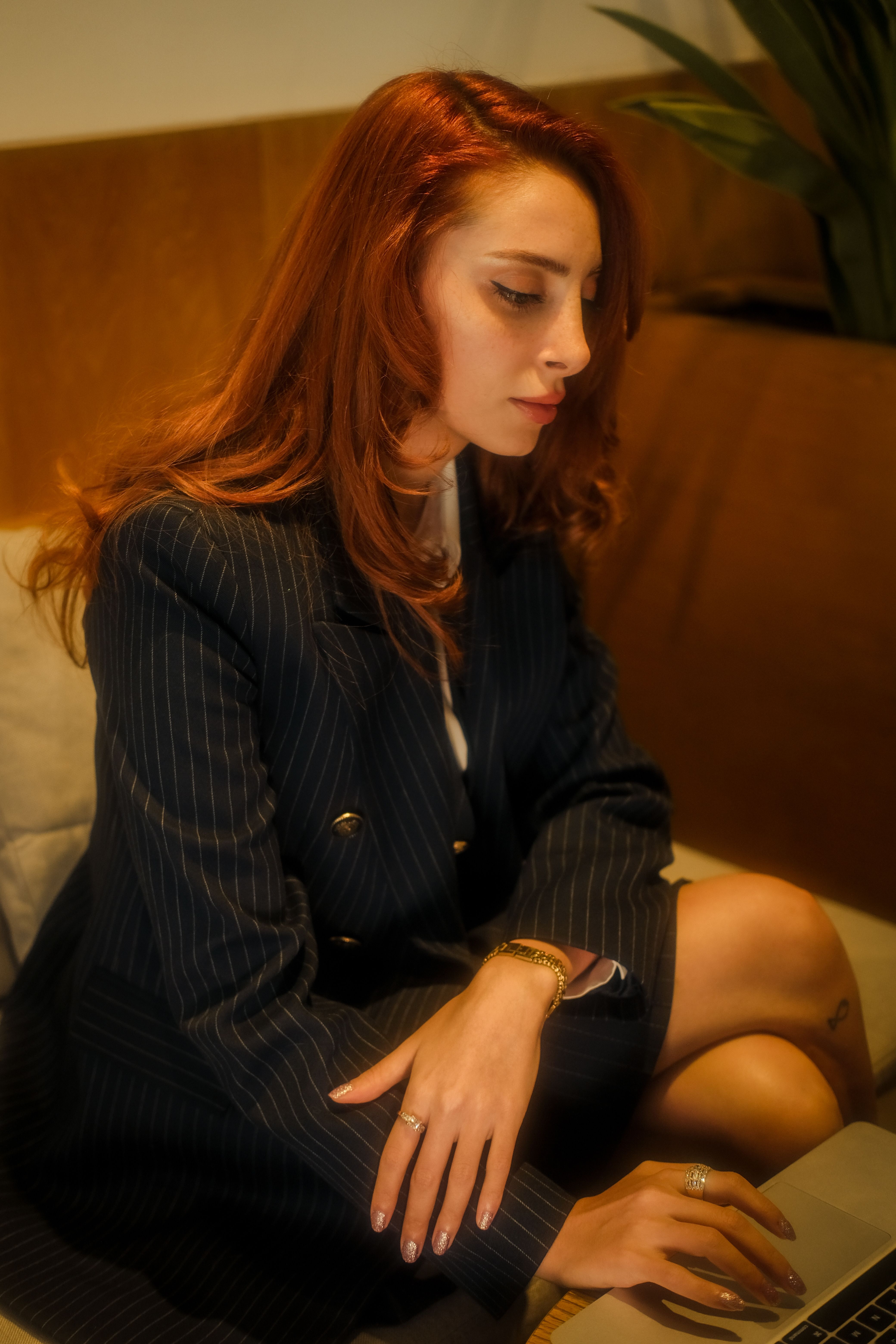 Redhead Woman Sitting in Suit · Free Stock Photo