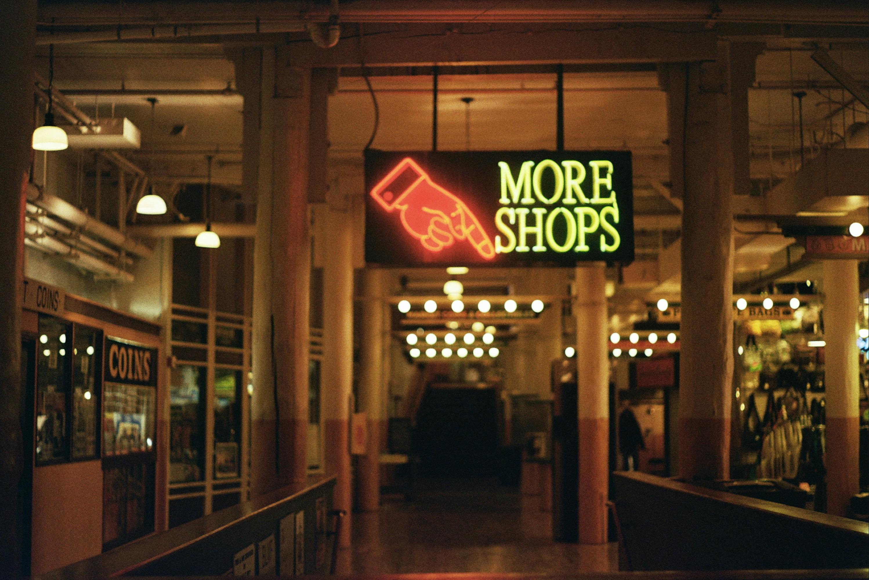 A neon sign that says more shops in the middle of a building · Free ...