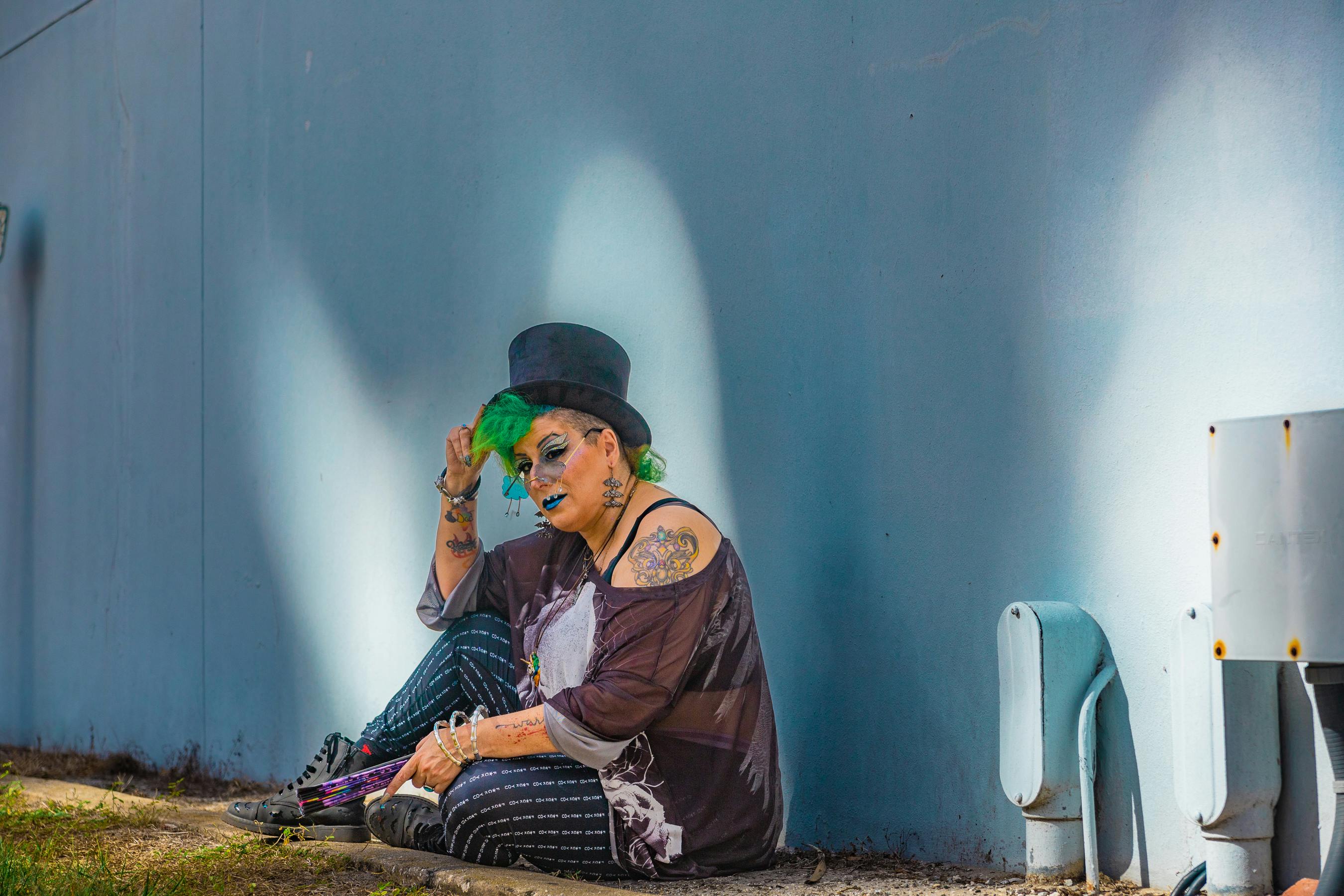 Punk Woman Sitting in front of the Blue Wall · Free Stock Photo
