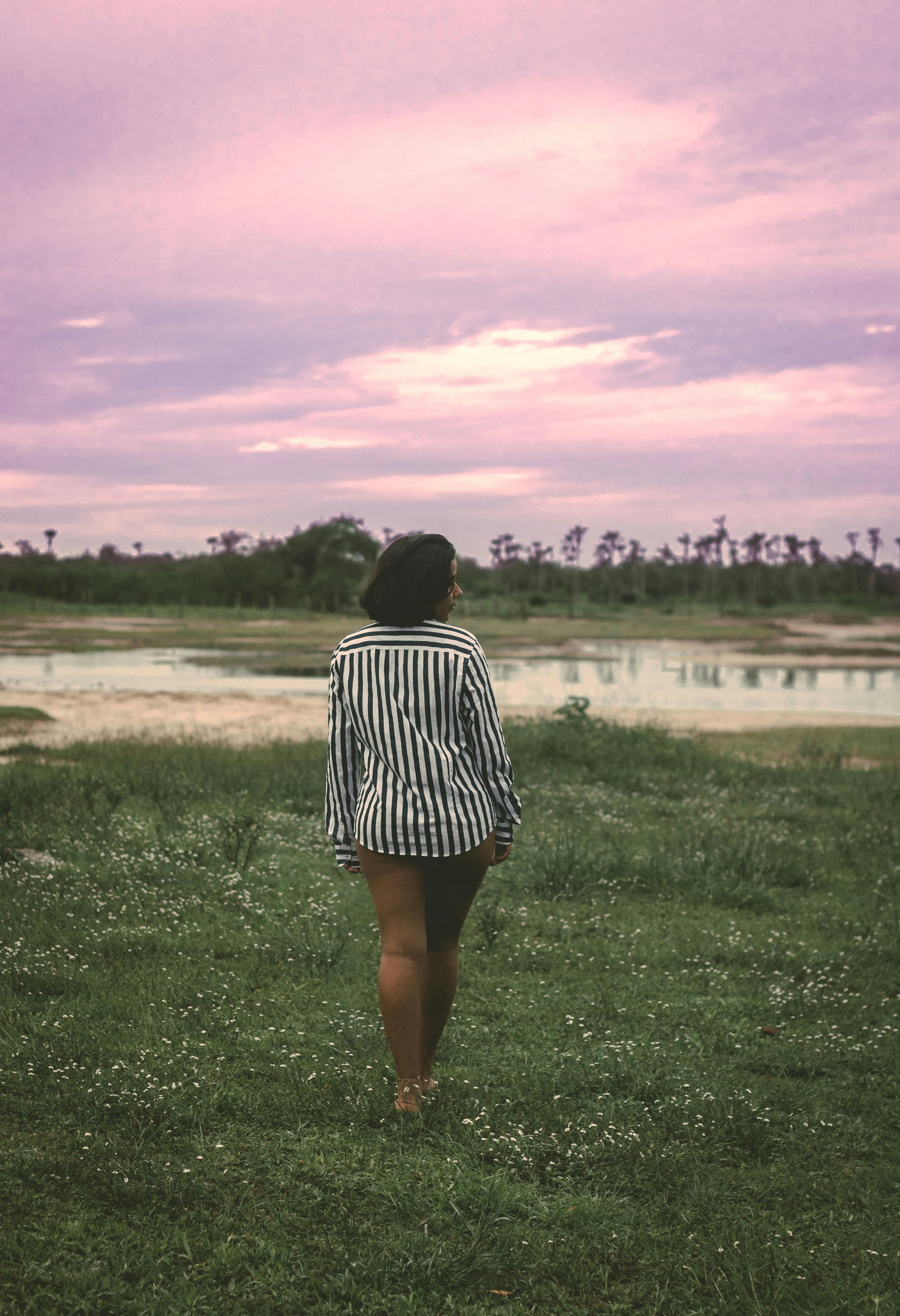 Black woman walking in calm marshland · Free Stock Photo