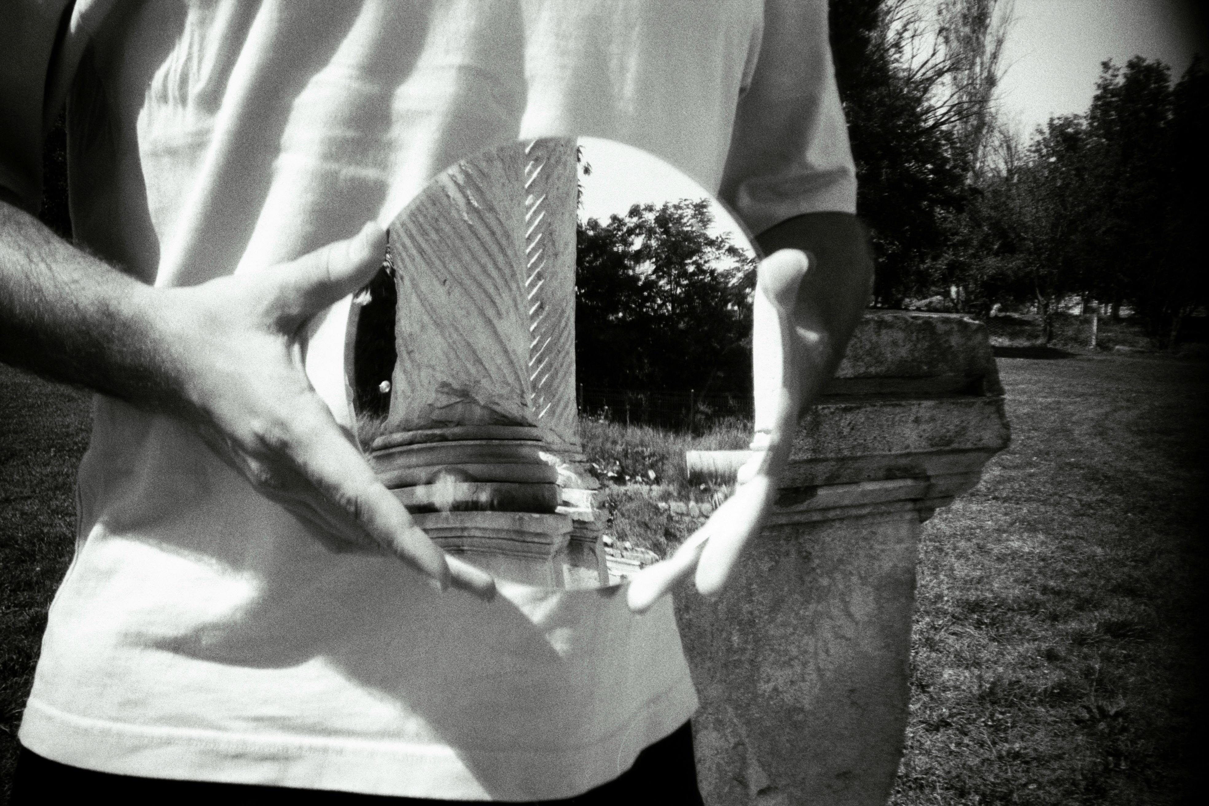 Cirled Mirror with a Reflection of a Column Held by a Man in the Park ...