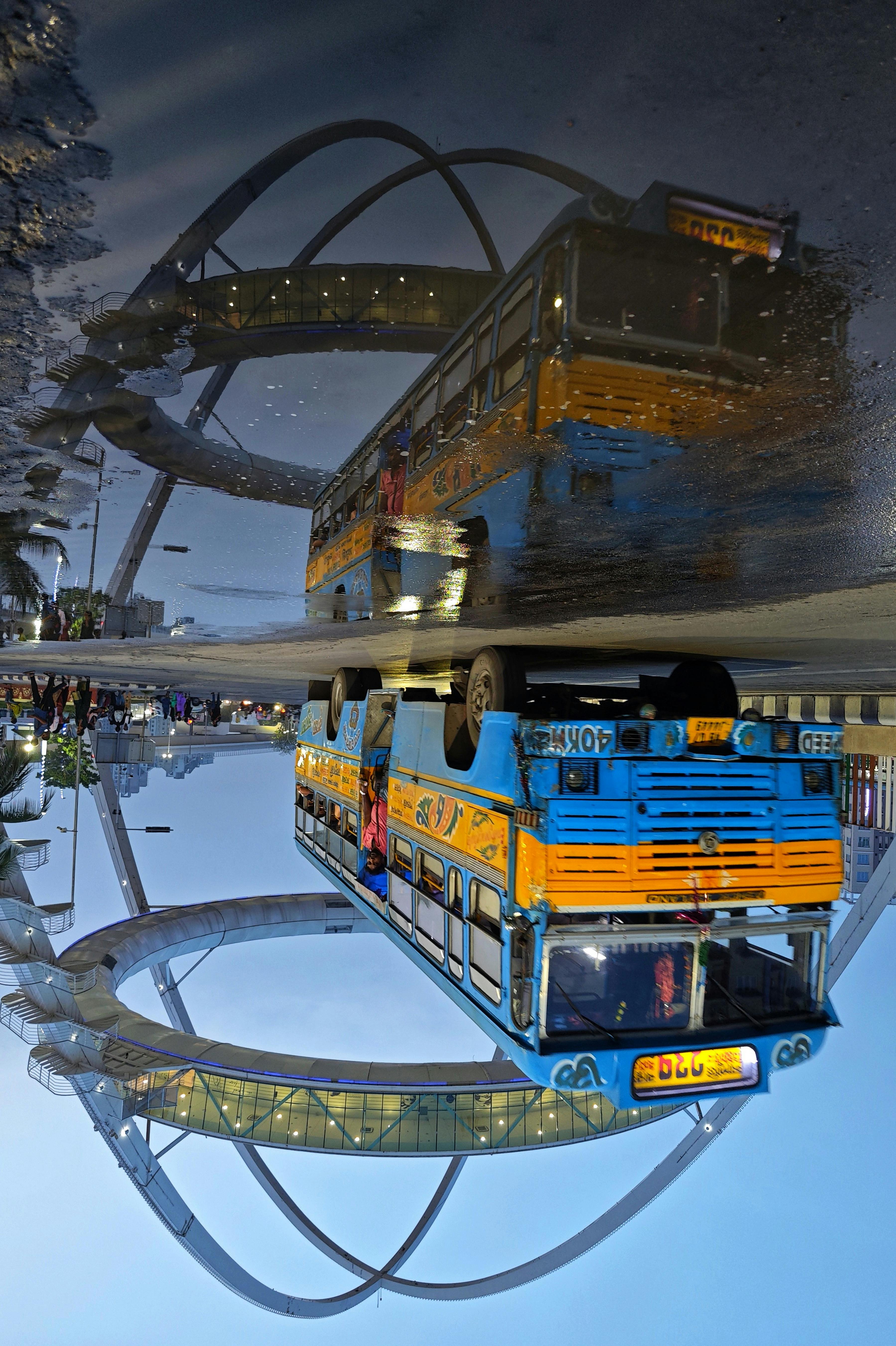 Symmetrical View of a Bus and a Build Structure, Reflecting in a Puddle ...