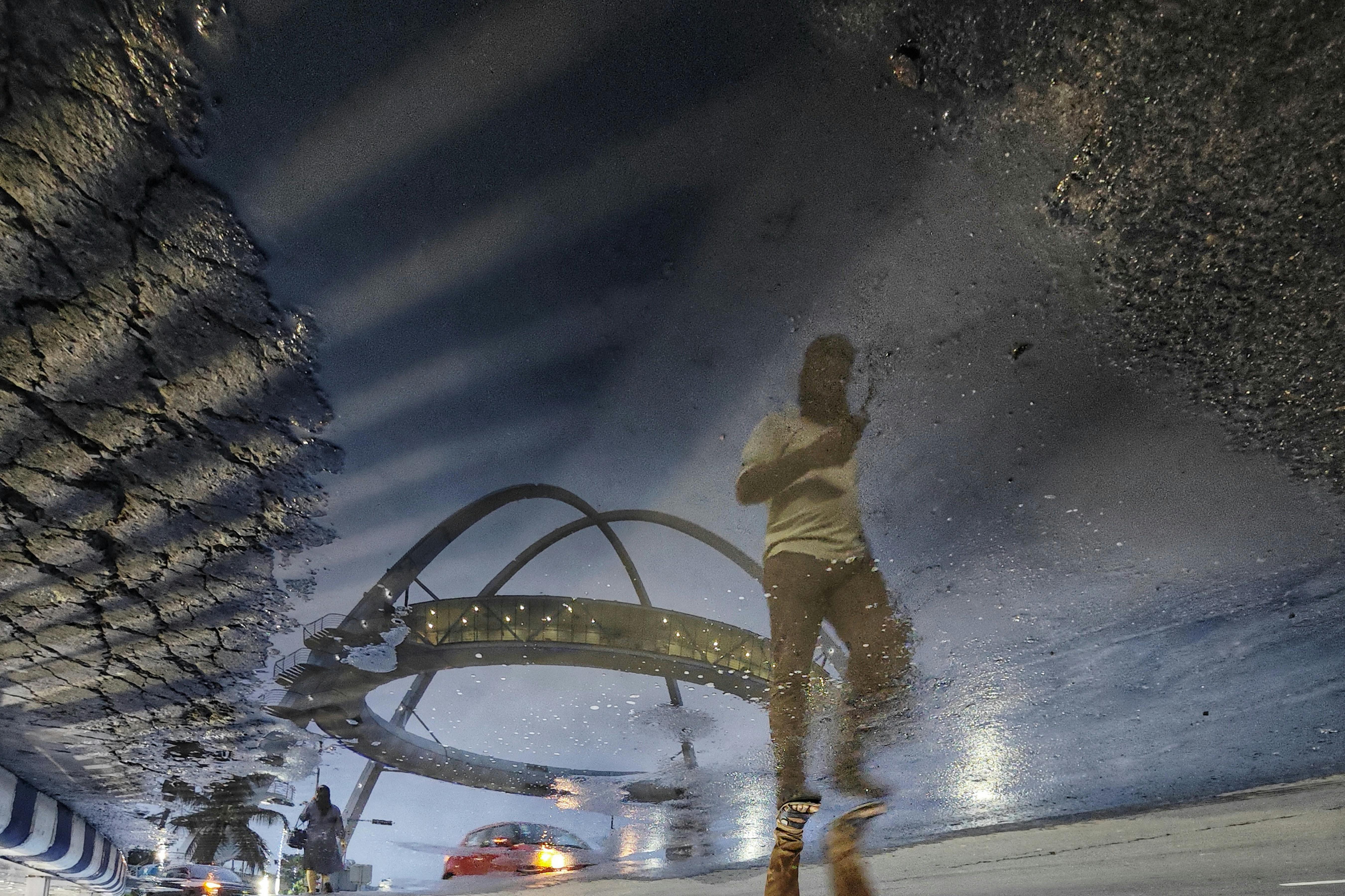 Upside Down Photo of Reflection of Pedestrians in a Puddle on a Street ...