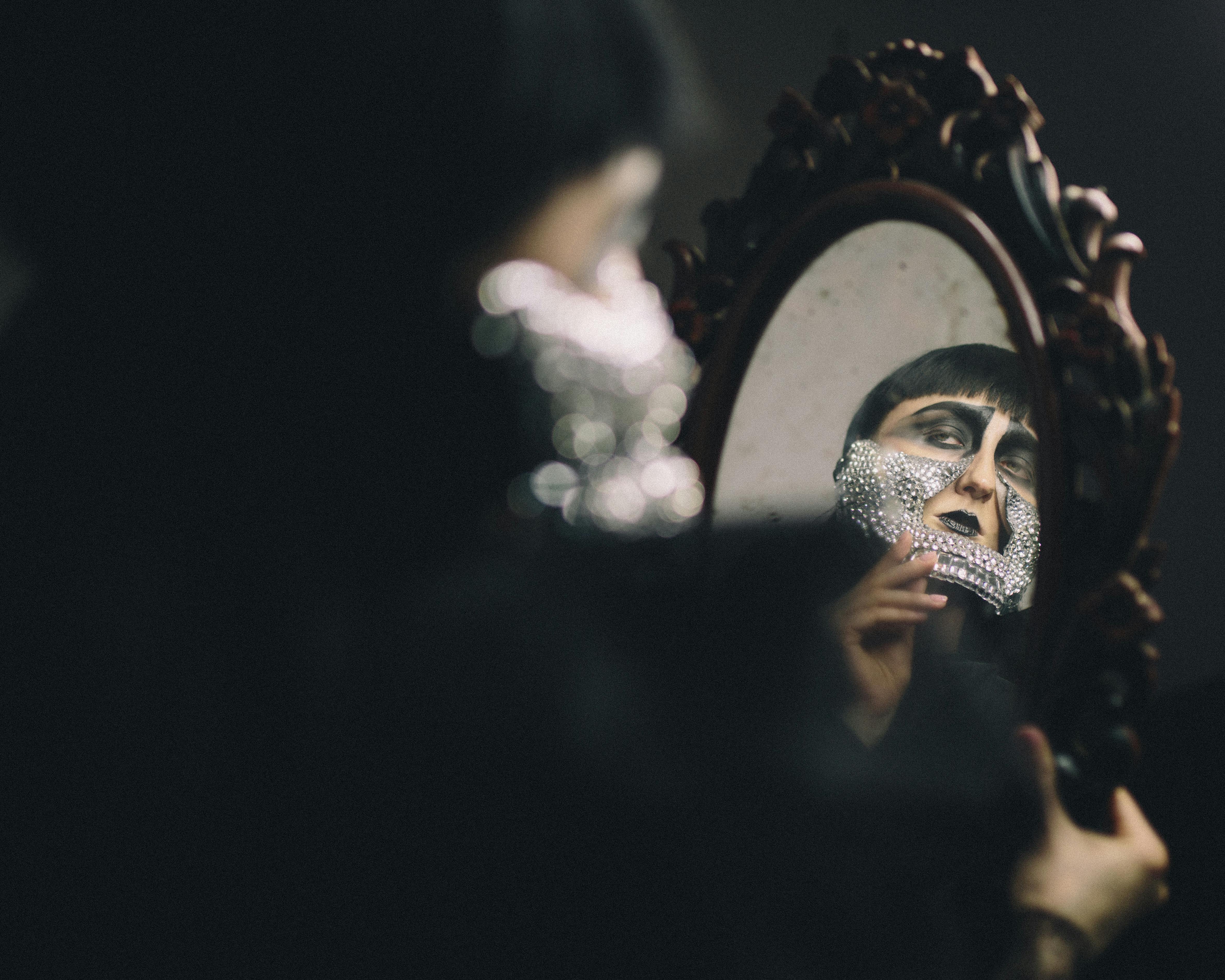 Actress Wearing a Dark Makeup and a Silver Mask, Reflecting in a ...