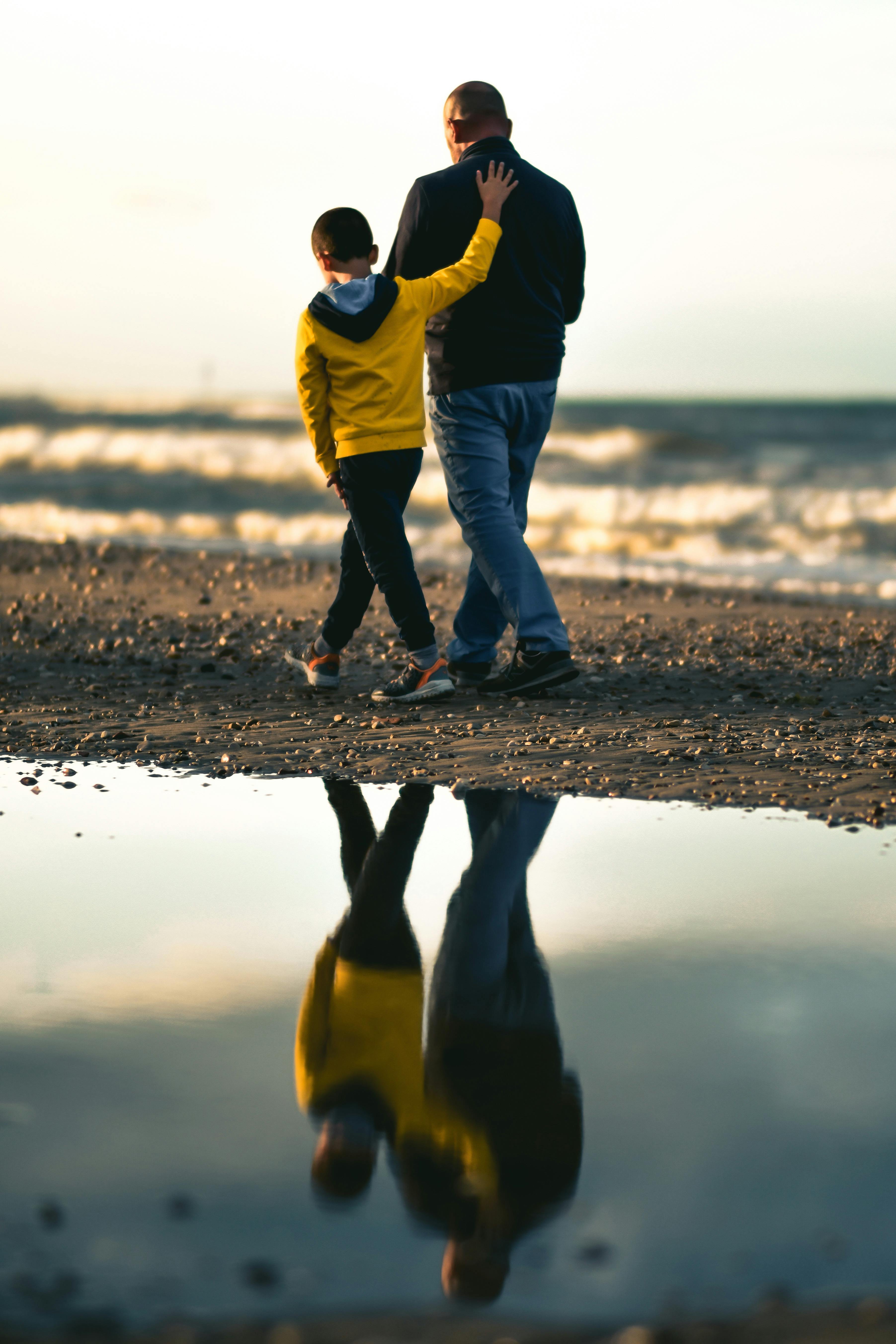 Back View of a Father and Son Walking on a Beach · Free Stock Photo