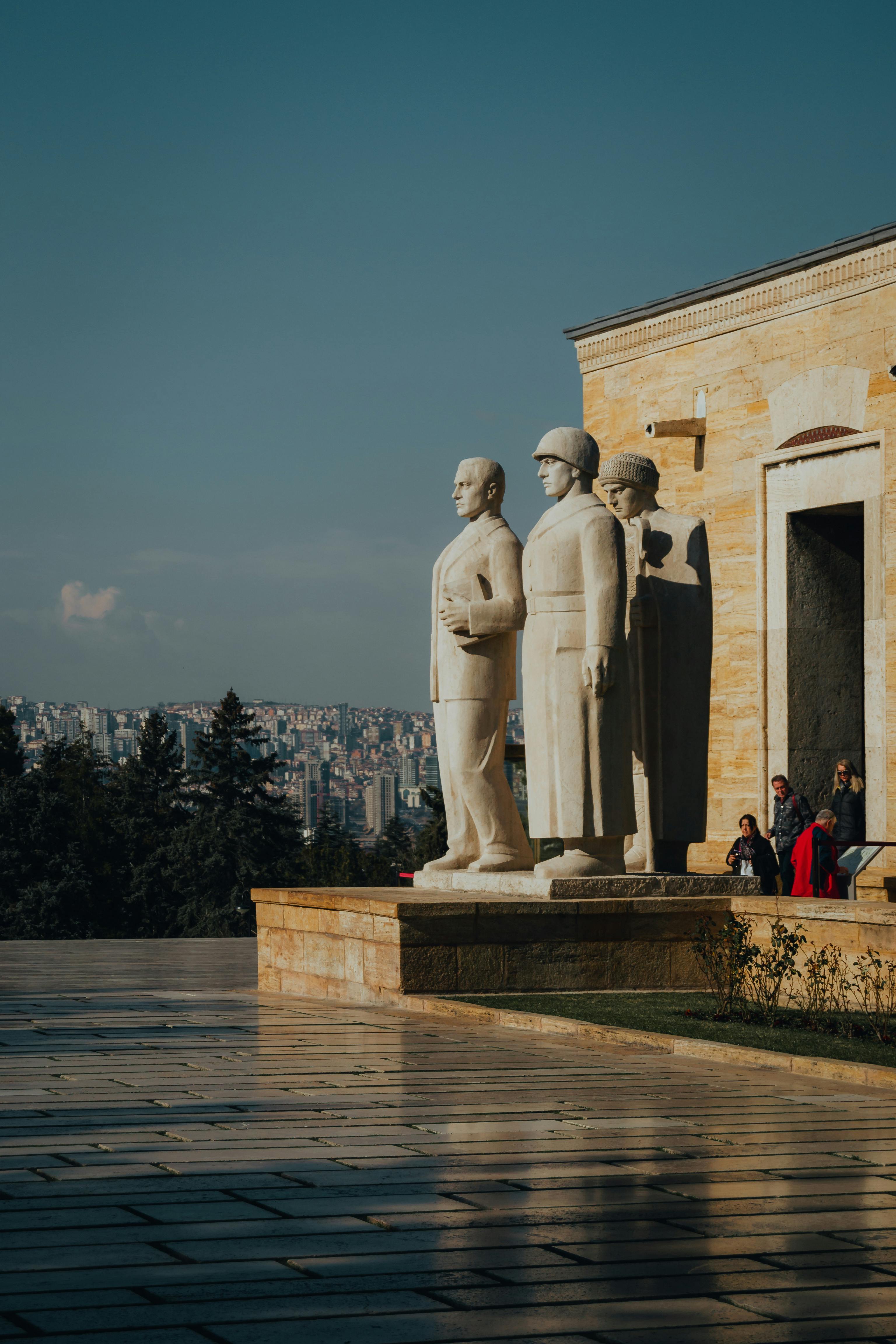 The statue of the three men is standing in front of a building · Free ...