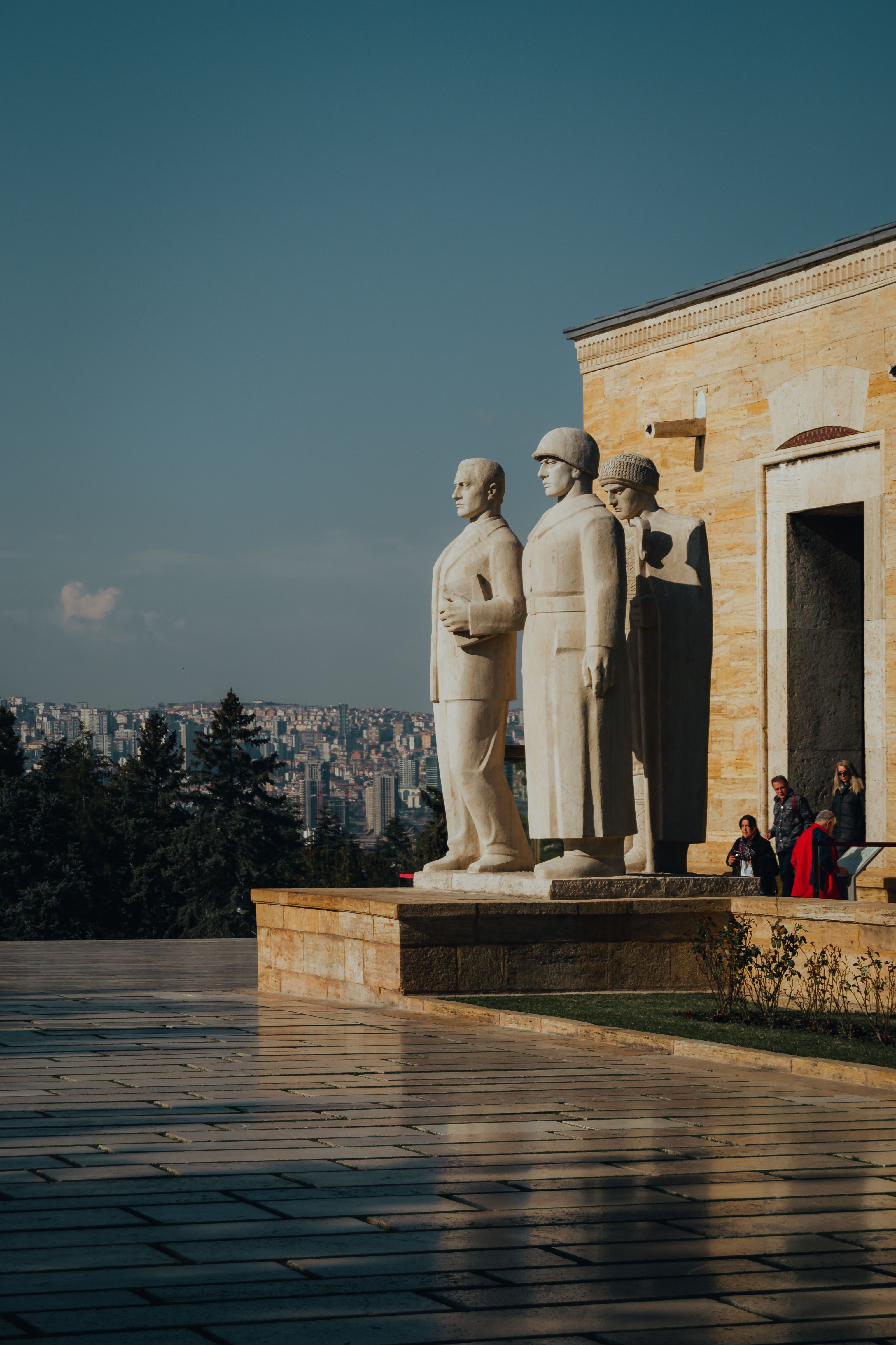 The statue of the three men is standing in front of a building · Free ...