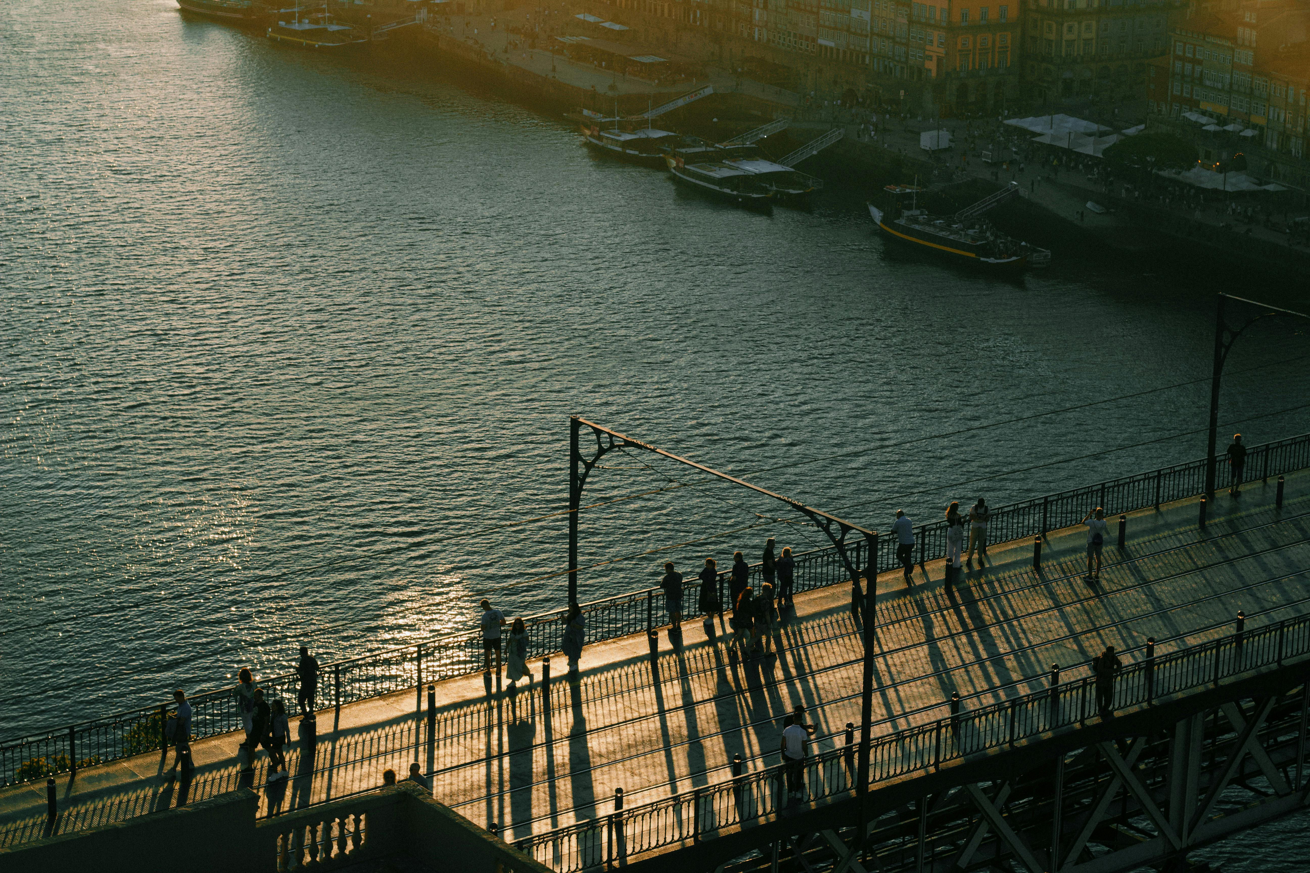 People Walking on a Bridge in the Sunset Over a Lake · Free Stock Photo