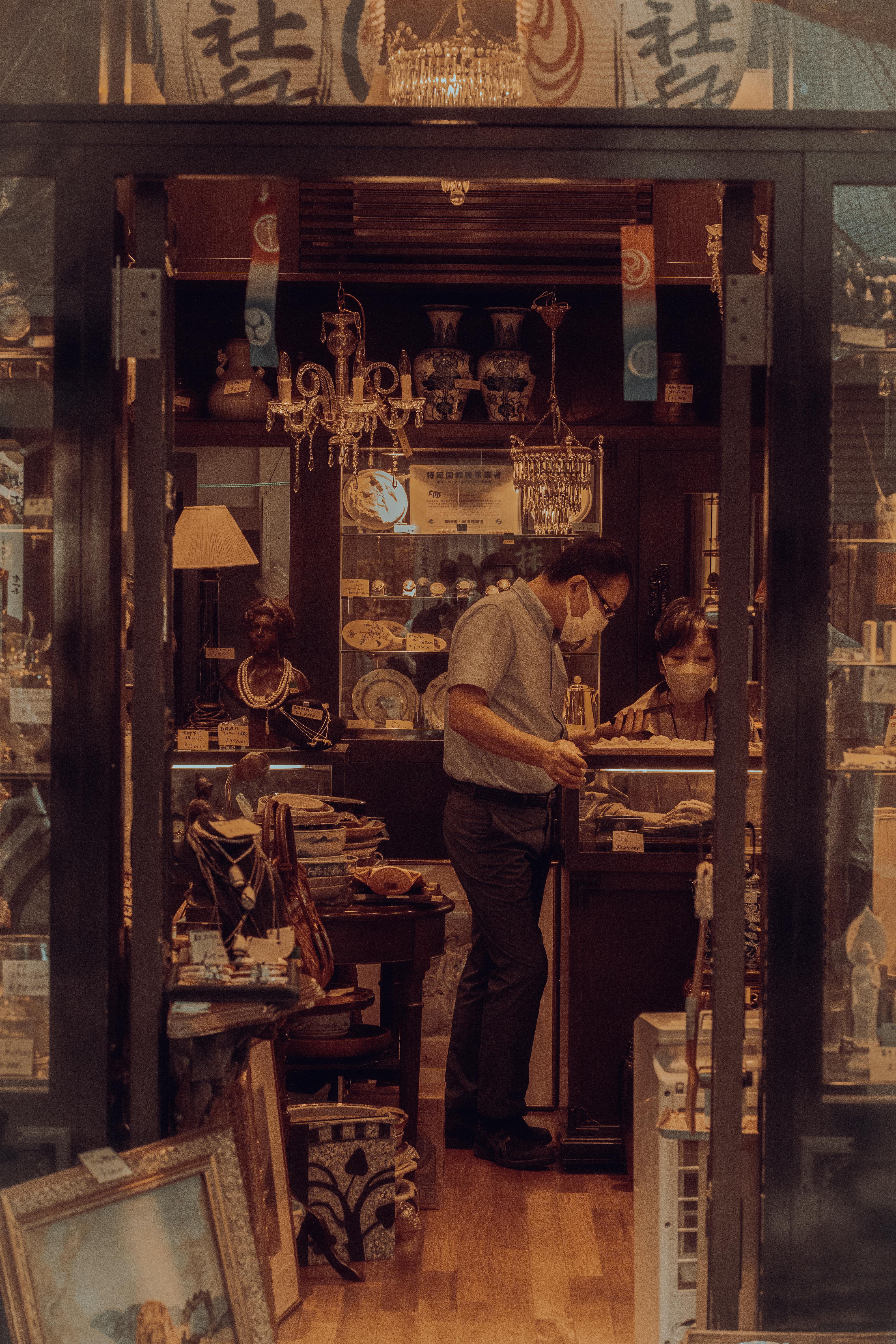A man is standing in front of a store with a sign that says, the best ...