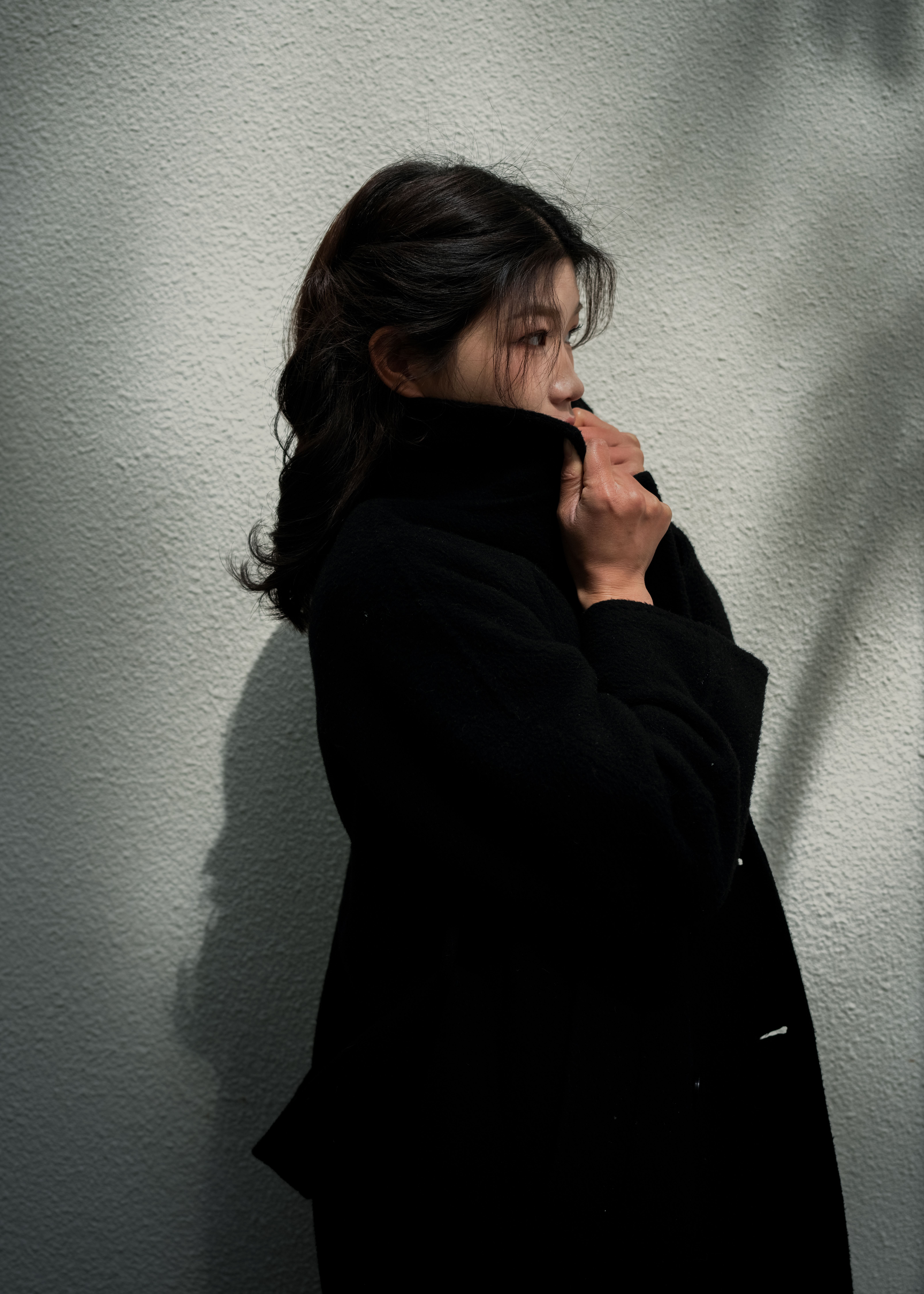 Woman Hiding behind Large Black Coat · Free Stock Photo