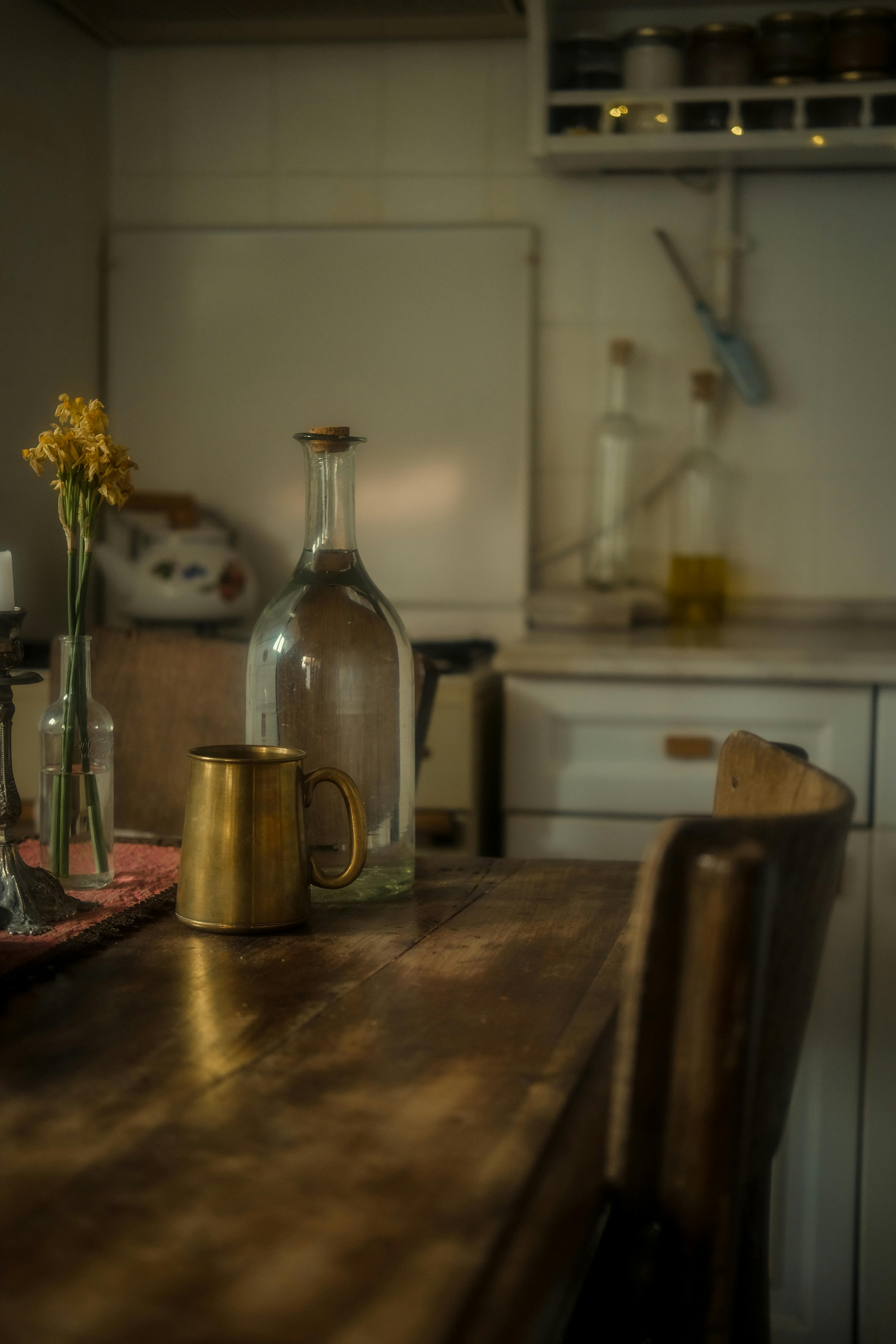 Cup and a Glass Bottle on a Kitchen Table · Free Stock Photo