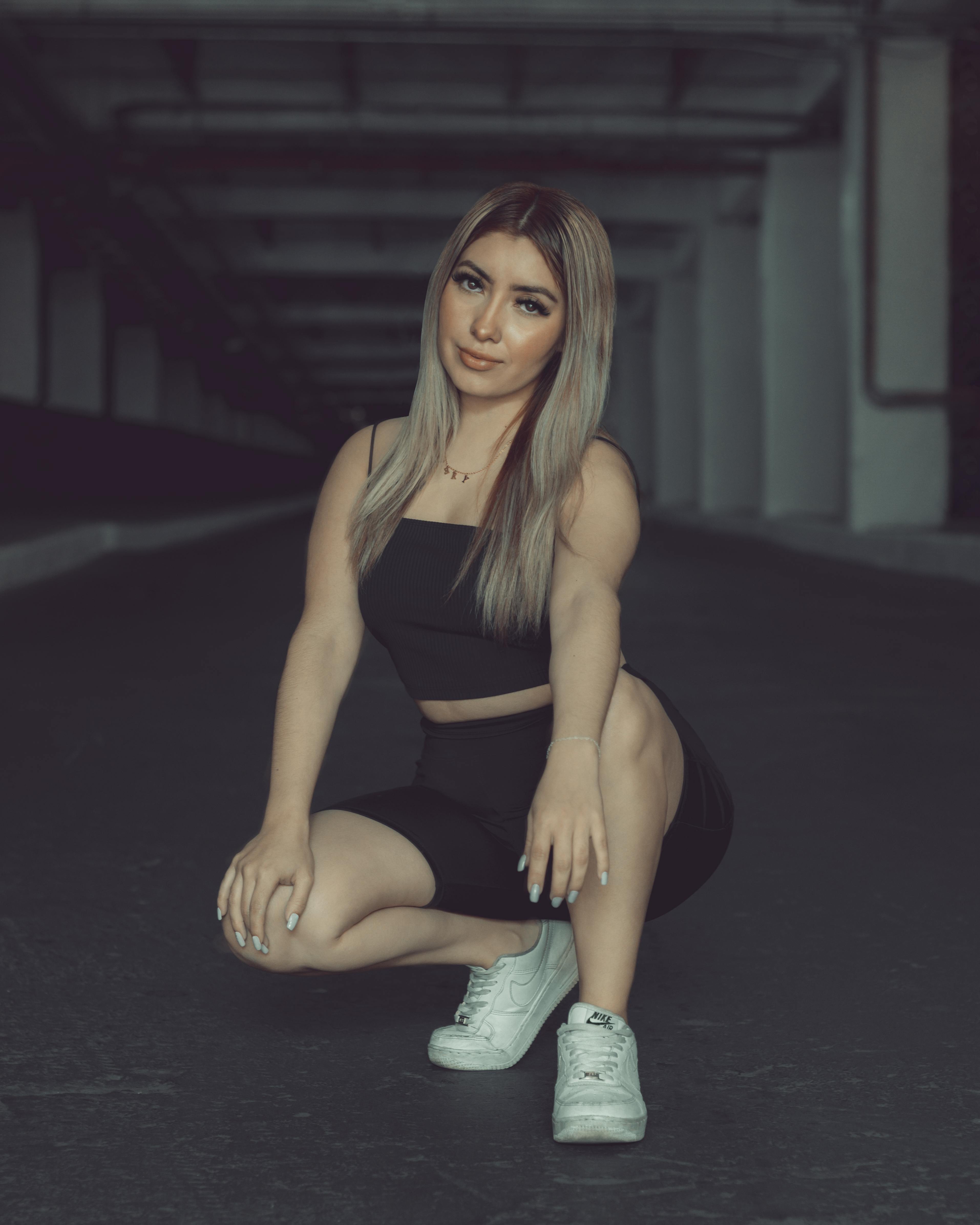 Blonde Woman in Black Sportswear Squatting on Street · Free Stock Photo