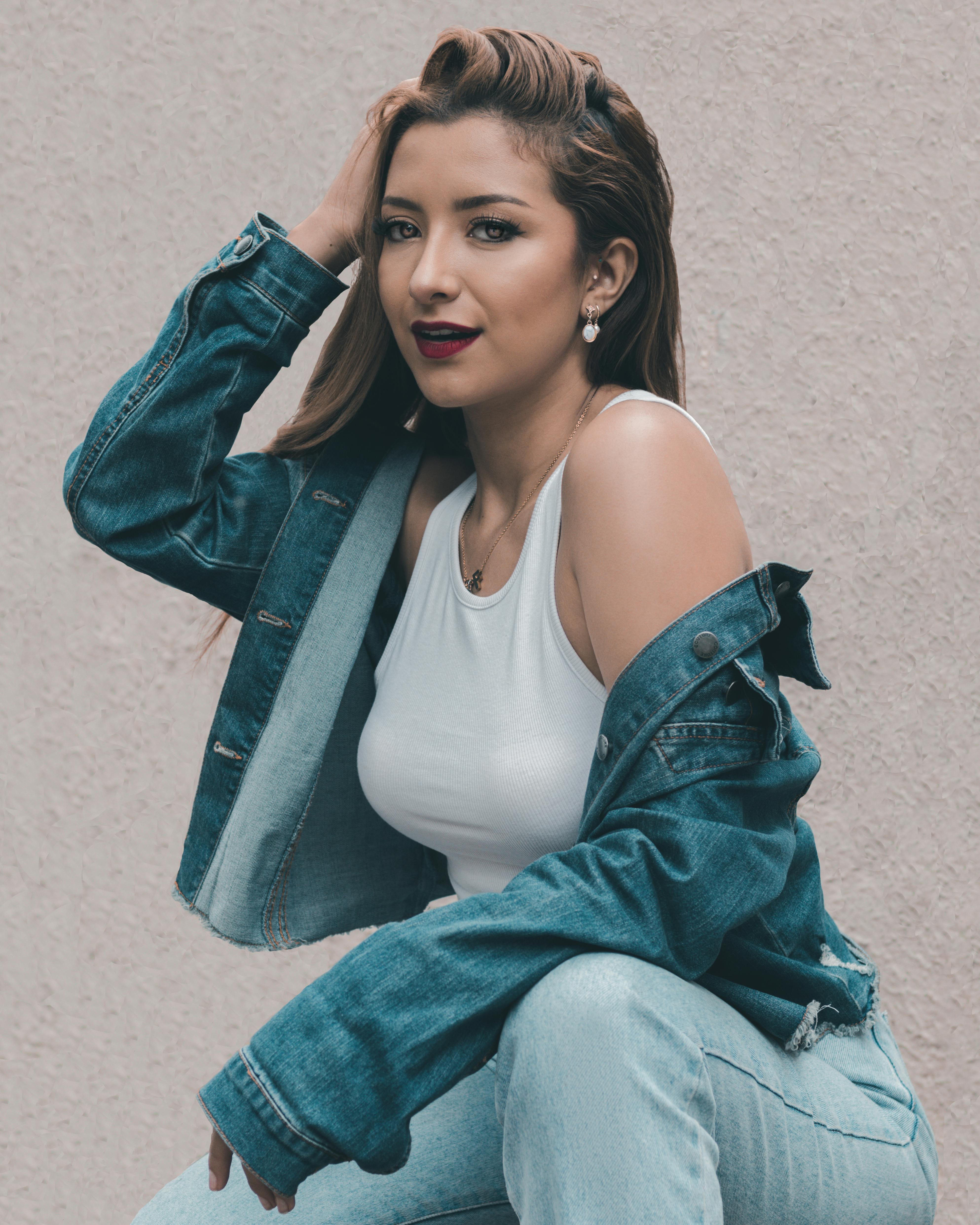Woman Crouching in Jean Jacket · Free Stock Photo
