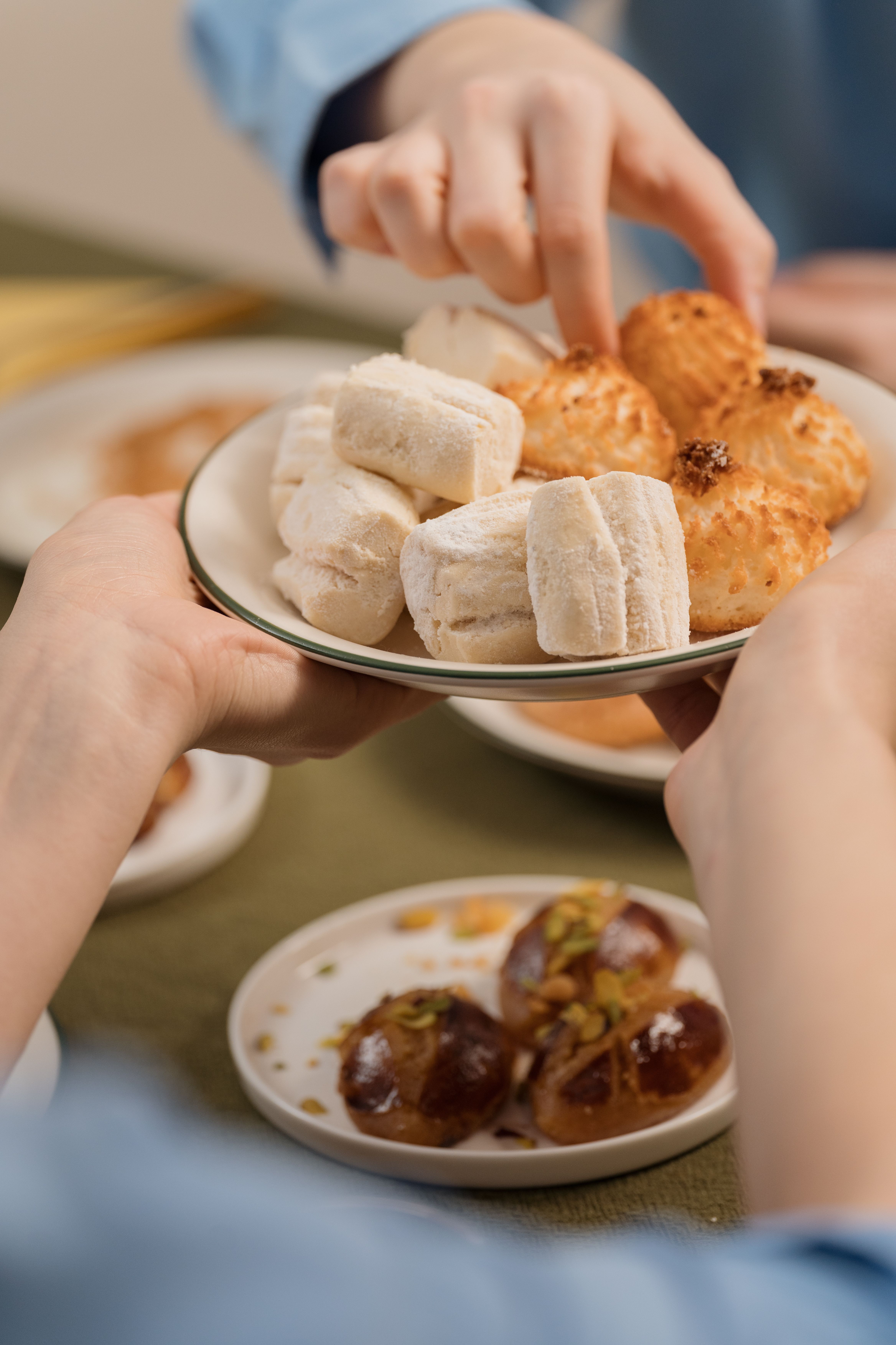 Close-up of a Person Taking a Pastry from a Plate · Free Stock Photo