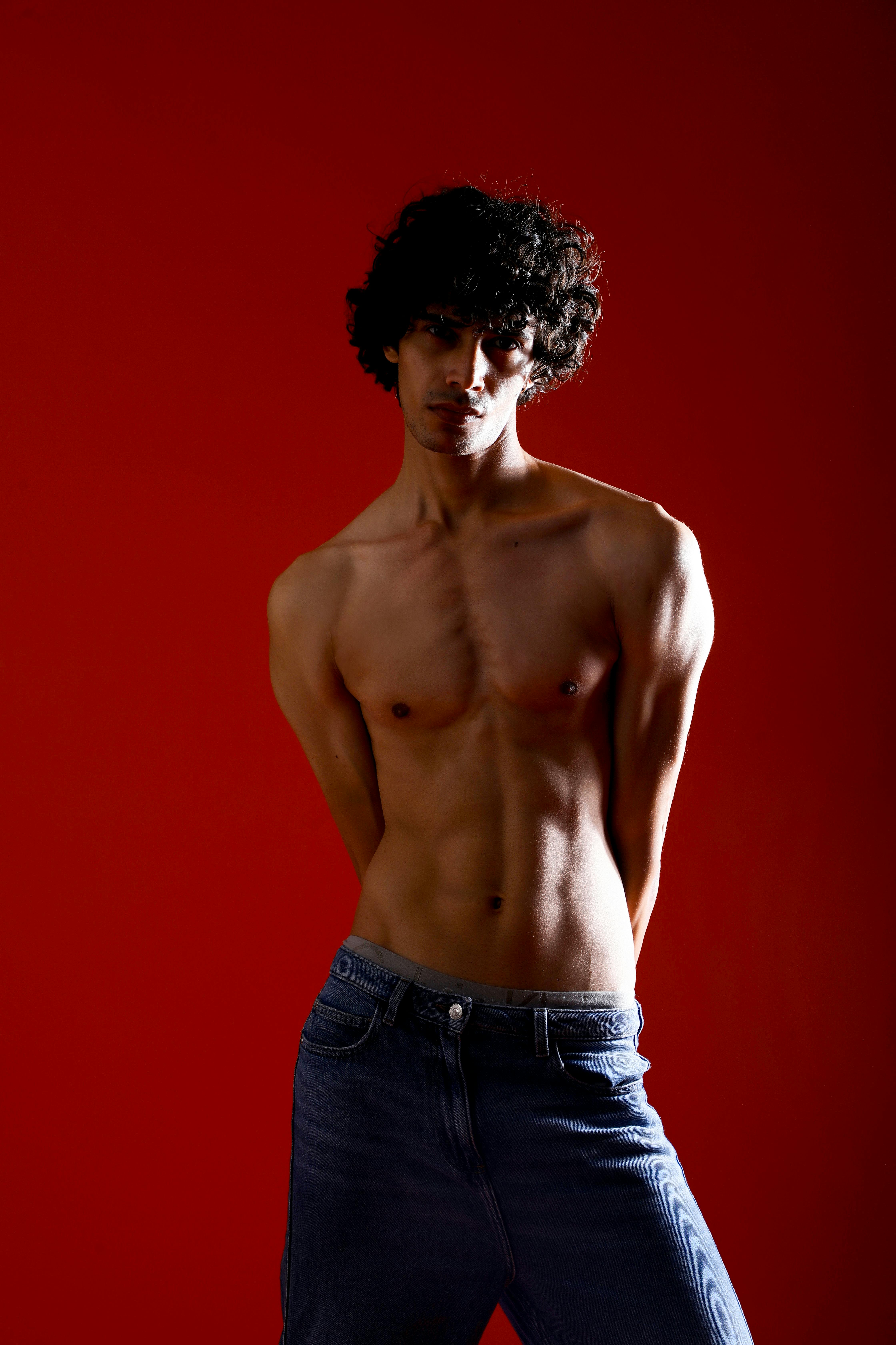 Man Without Shirt Posing in Red Studio · Free Stock Photo