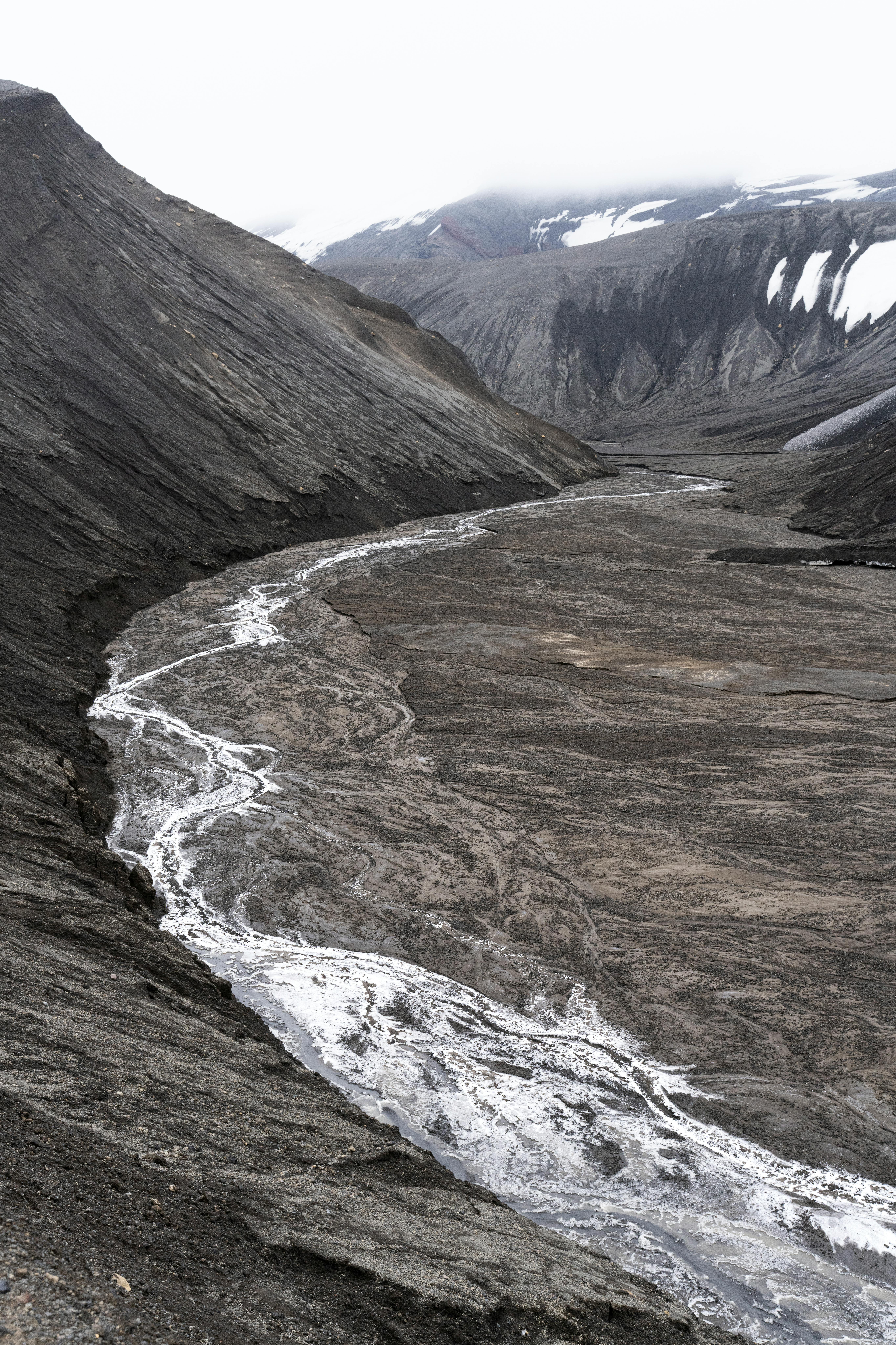 Frozen River Flowing through a Desolate Landscape · Free Stock Photo