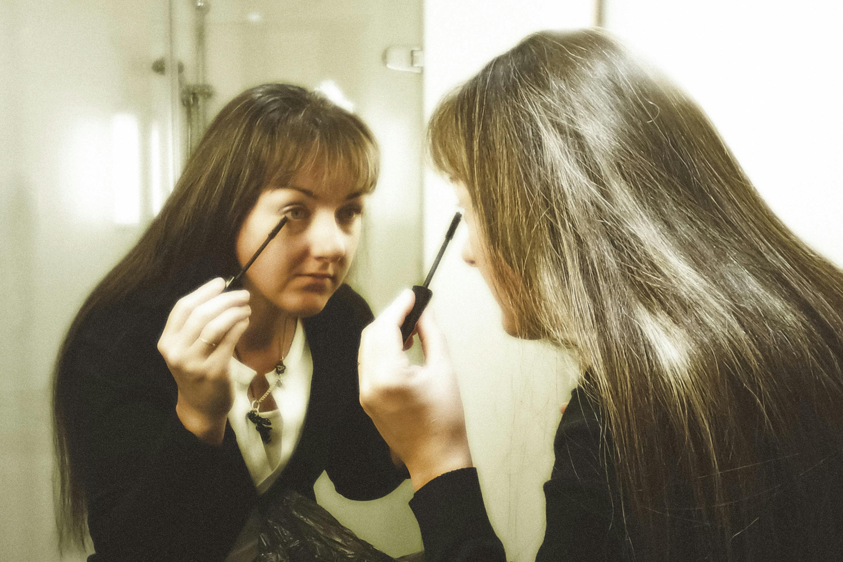 Brunette Girl in School Uniform Putting on Makeup in Bathroom · Free ...